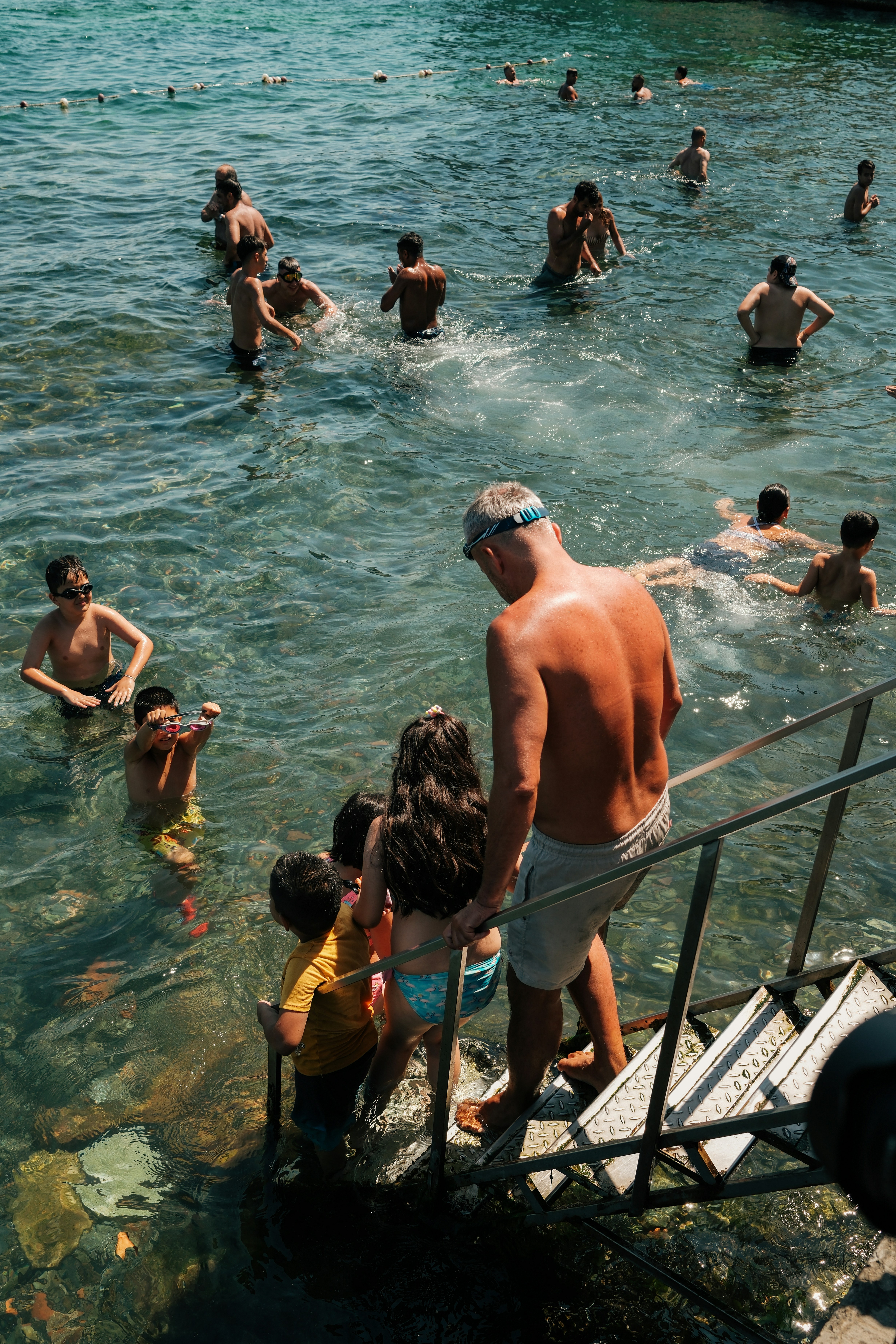 Stairway to the Sea: Sunlit Crowd at Turquoise Breakers