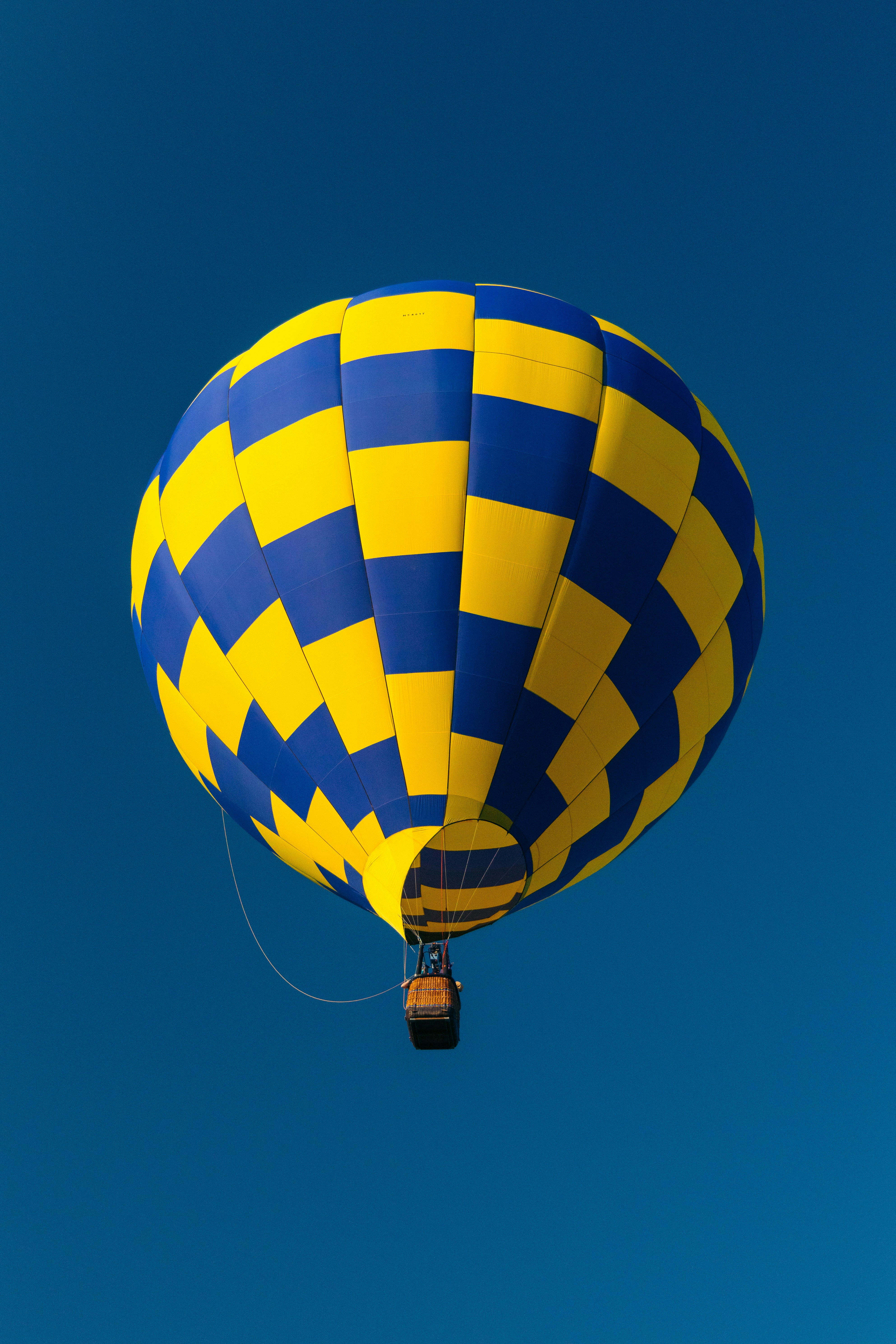 Geometric Ascend: A Yellow-Blue Balloon Drifting Against a Crystalline Sky