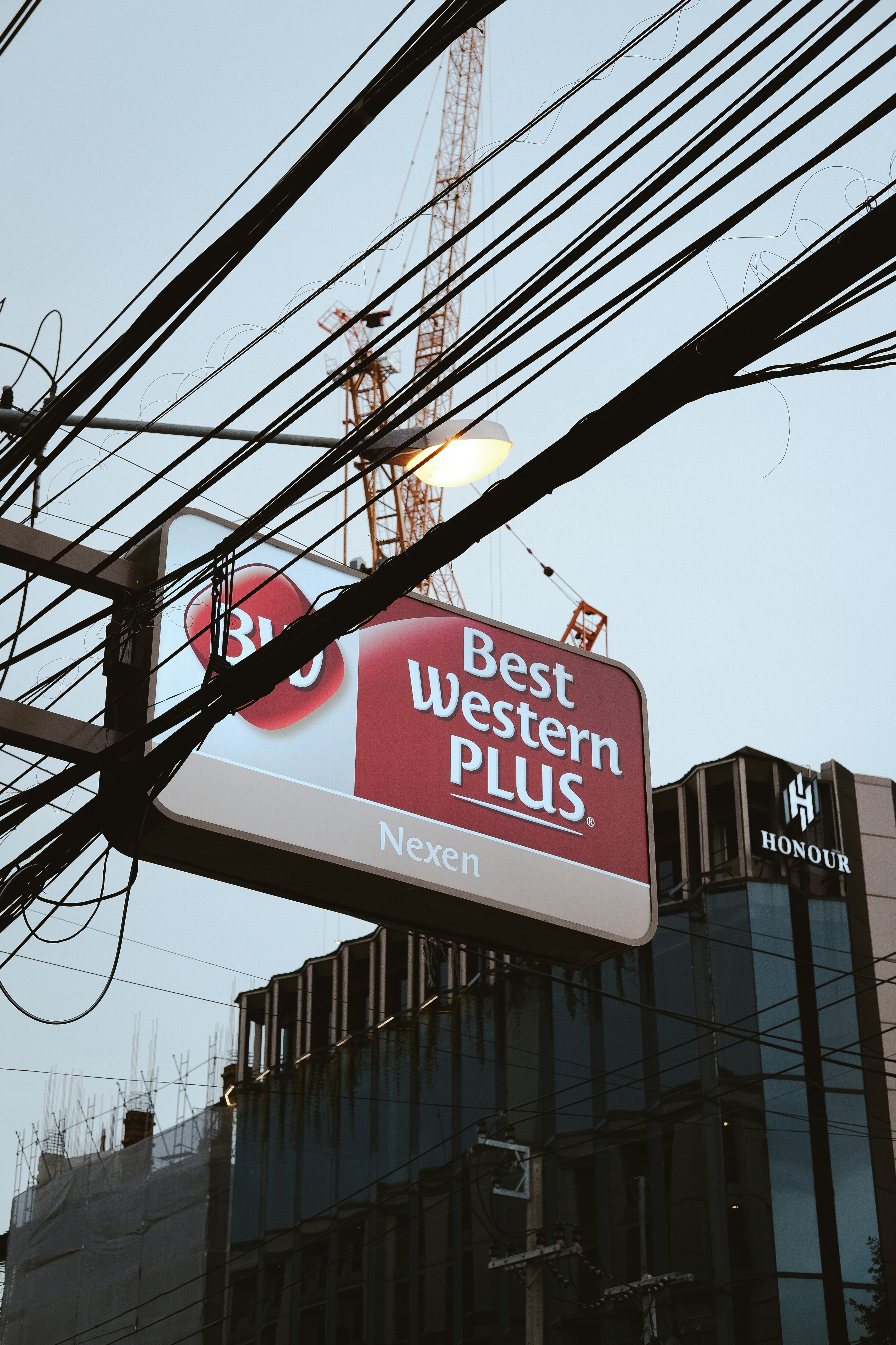 Best Western Plus Sign Framed by a Web of Urban Cables