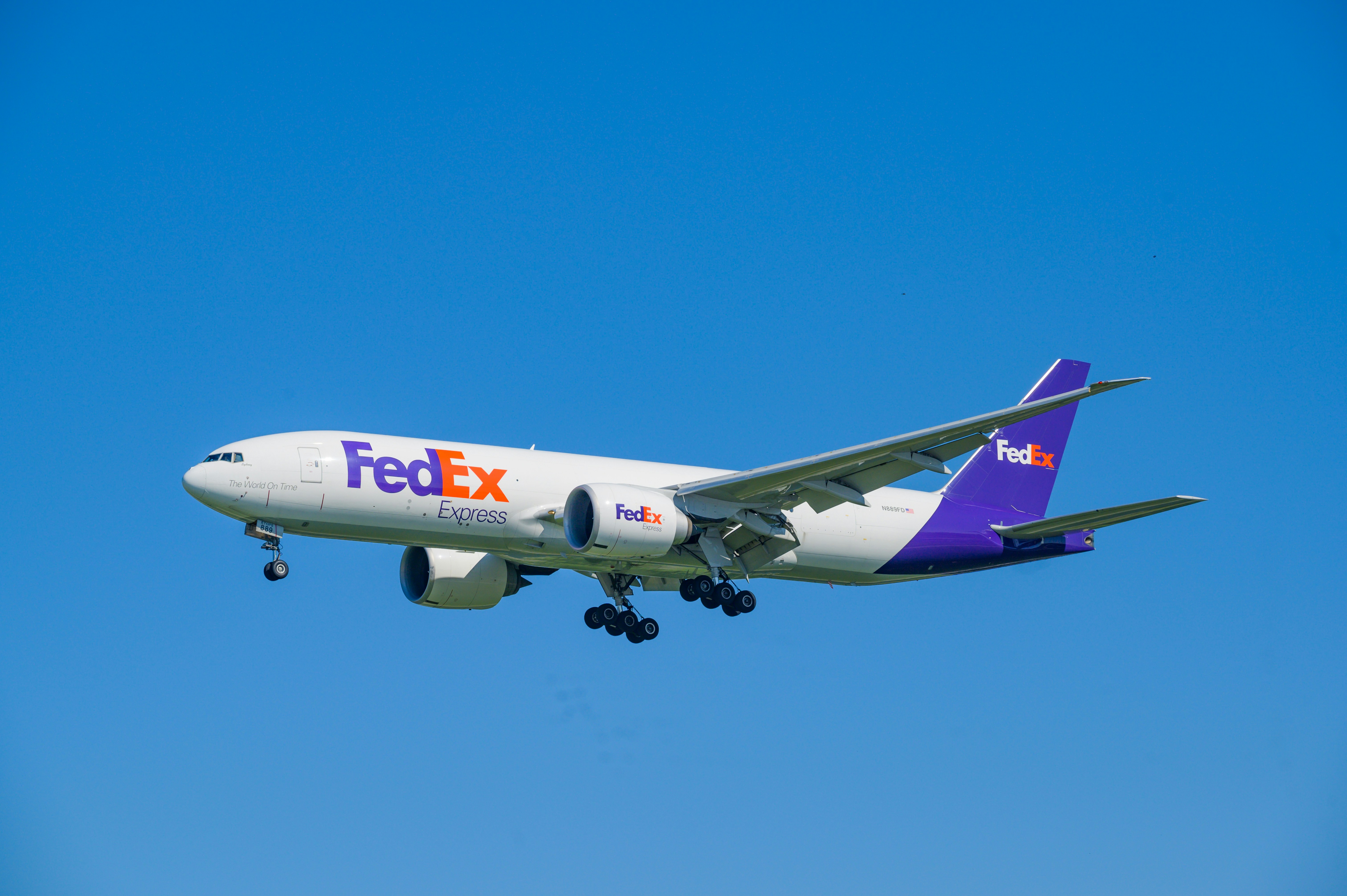 A fedex airplane flying in a clear blue sky photo – Free B777f Image on ...