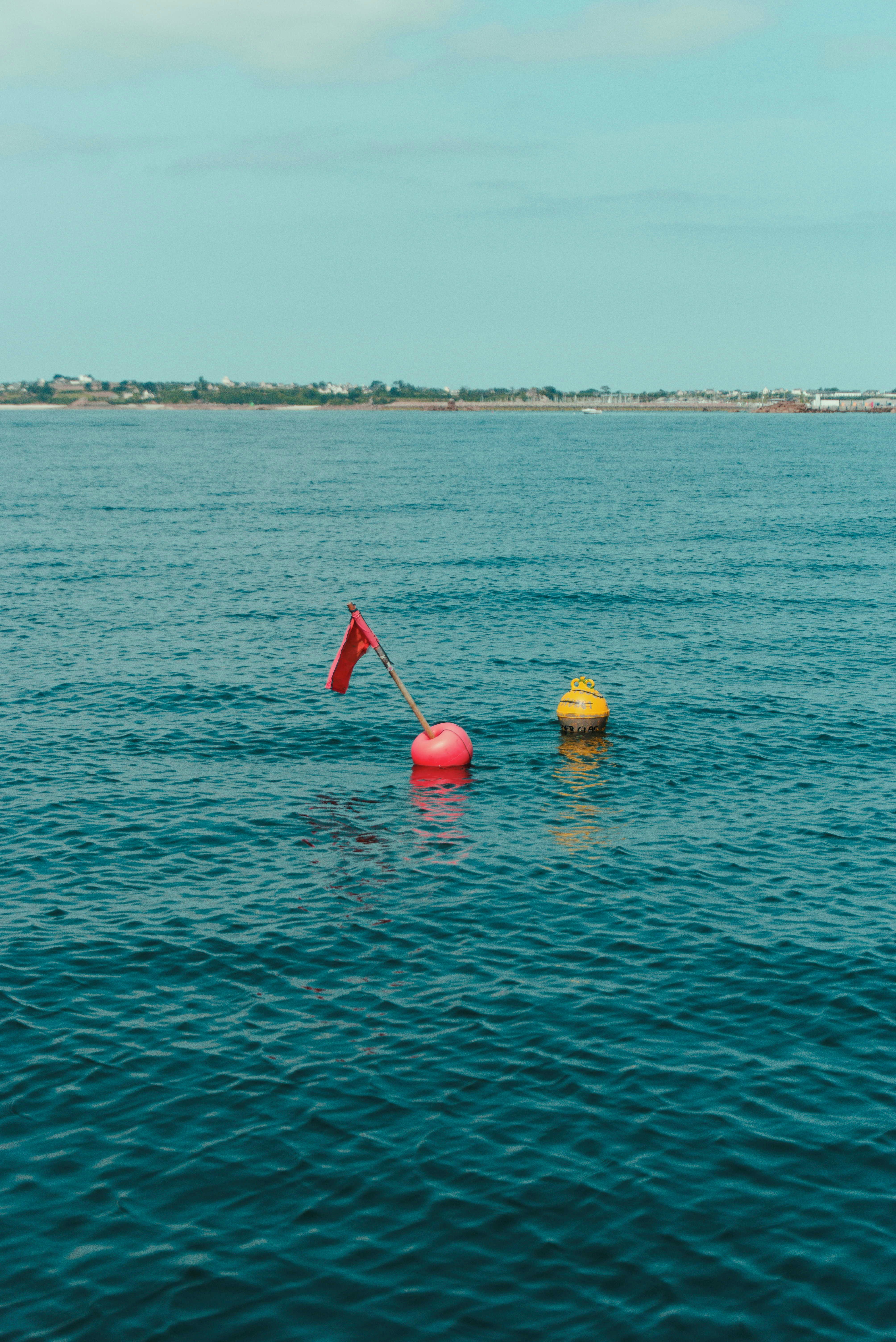 Two buoys floating in the middle of a body of water photo – Free Boat ...