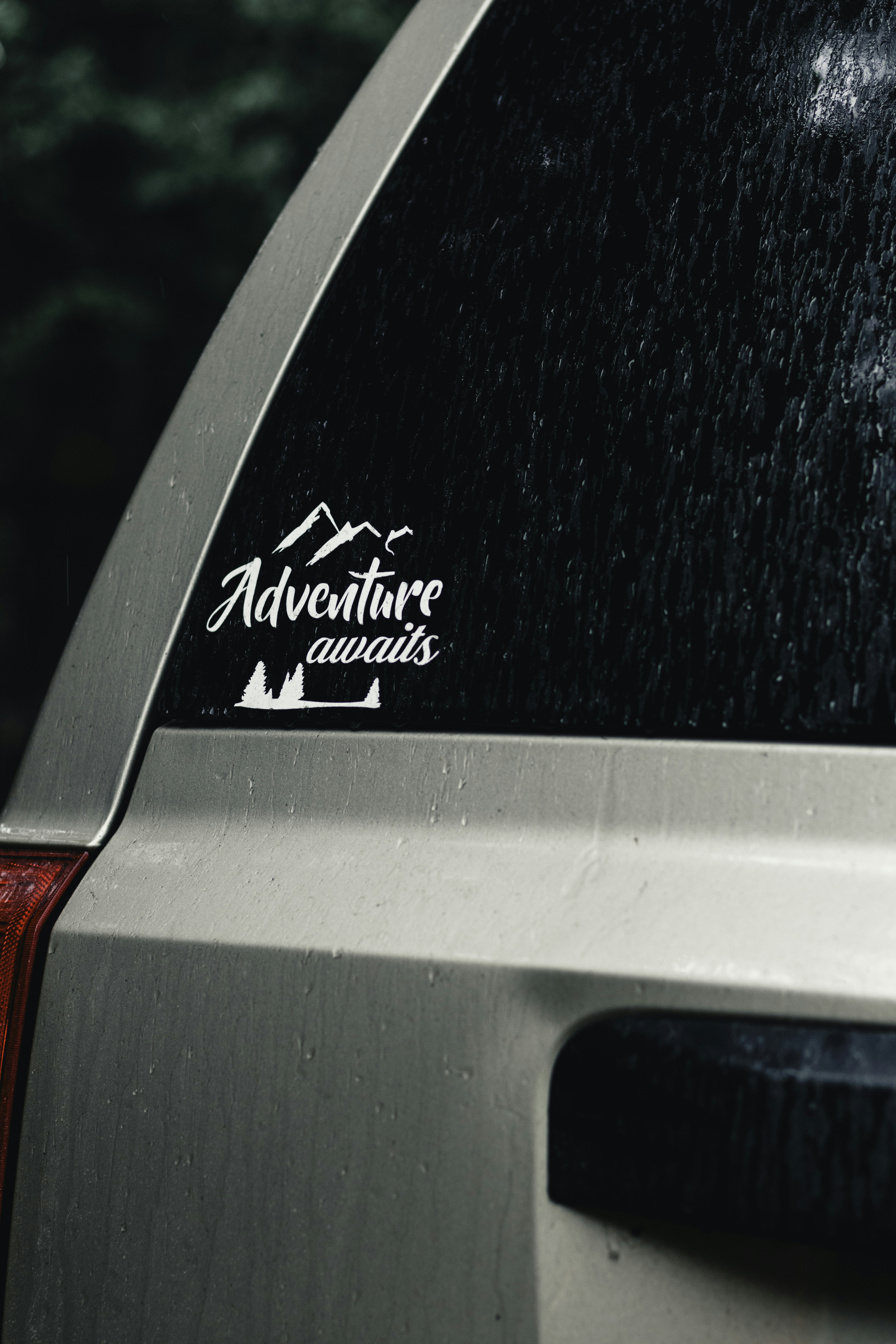 Stickered Skyline: Adventure Awaits on a Rain-Kissed Car