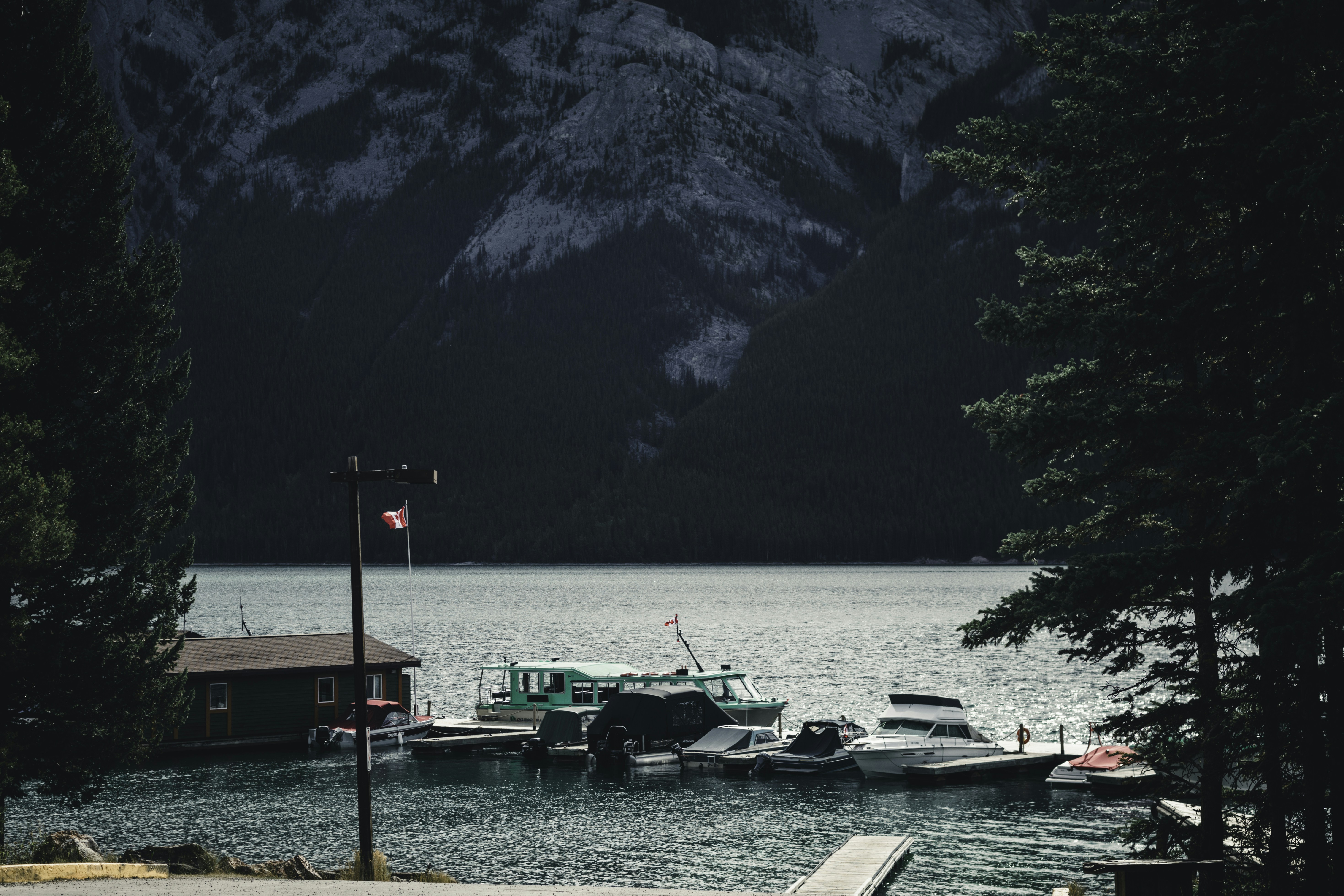 Boats at Quiet Lake Marina Beneath Shadowed Peaks