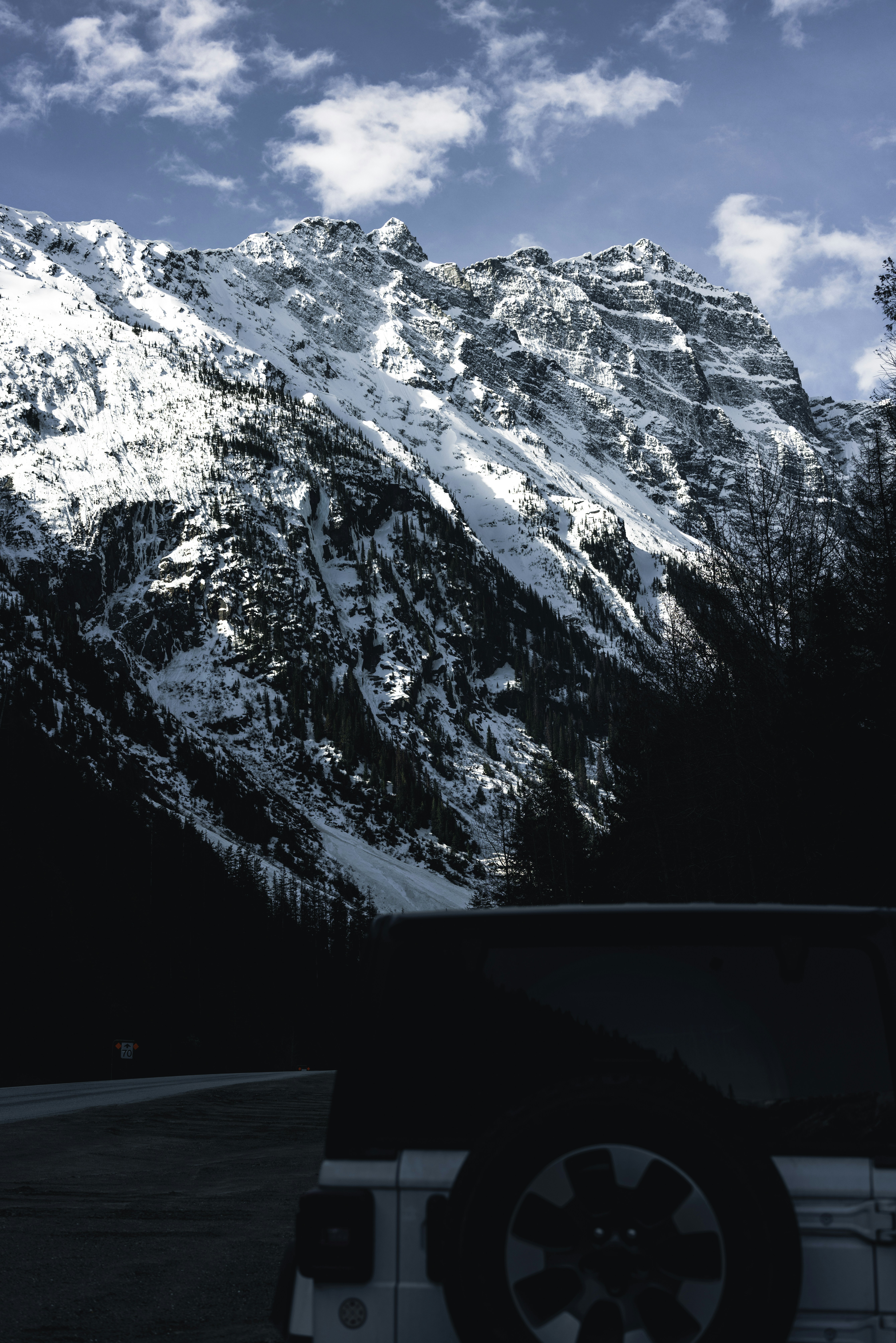 Snow-Crowned Ridge and a Silent Vehicle Silhouette