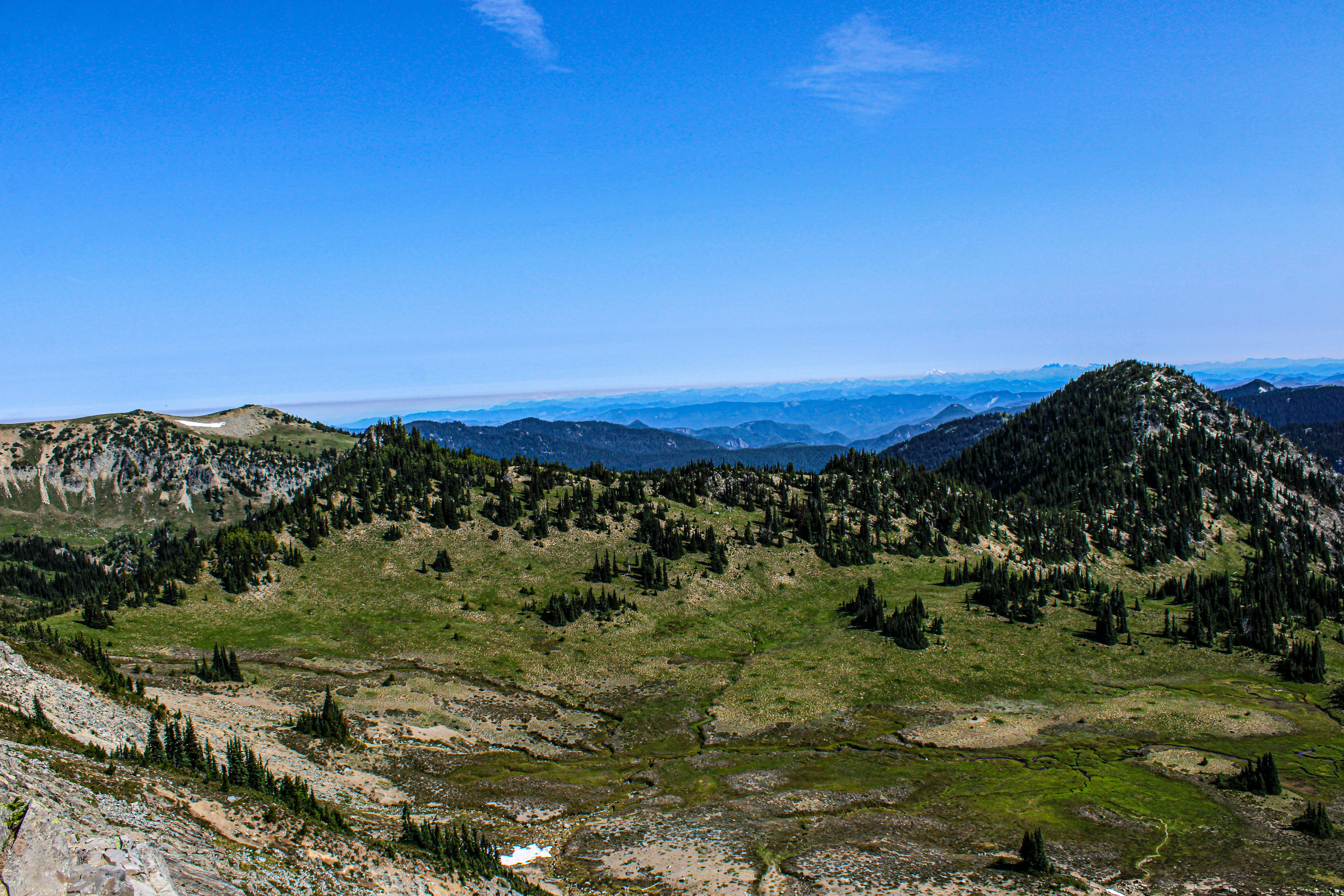 Azure Sky Over a Rugged Alpine Basin with Scattered Pines