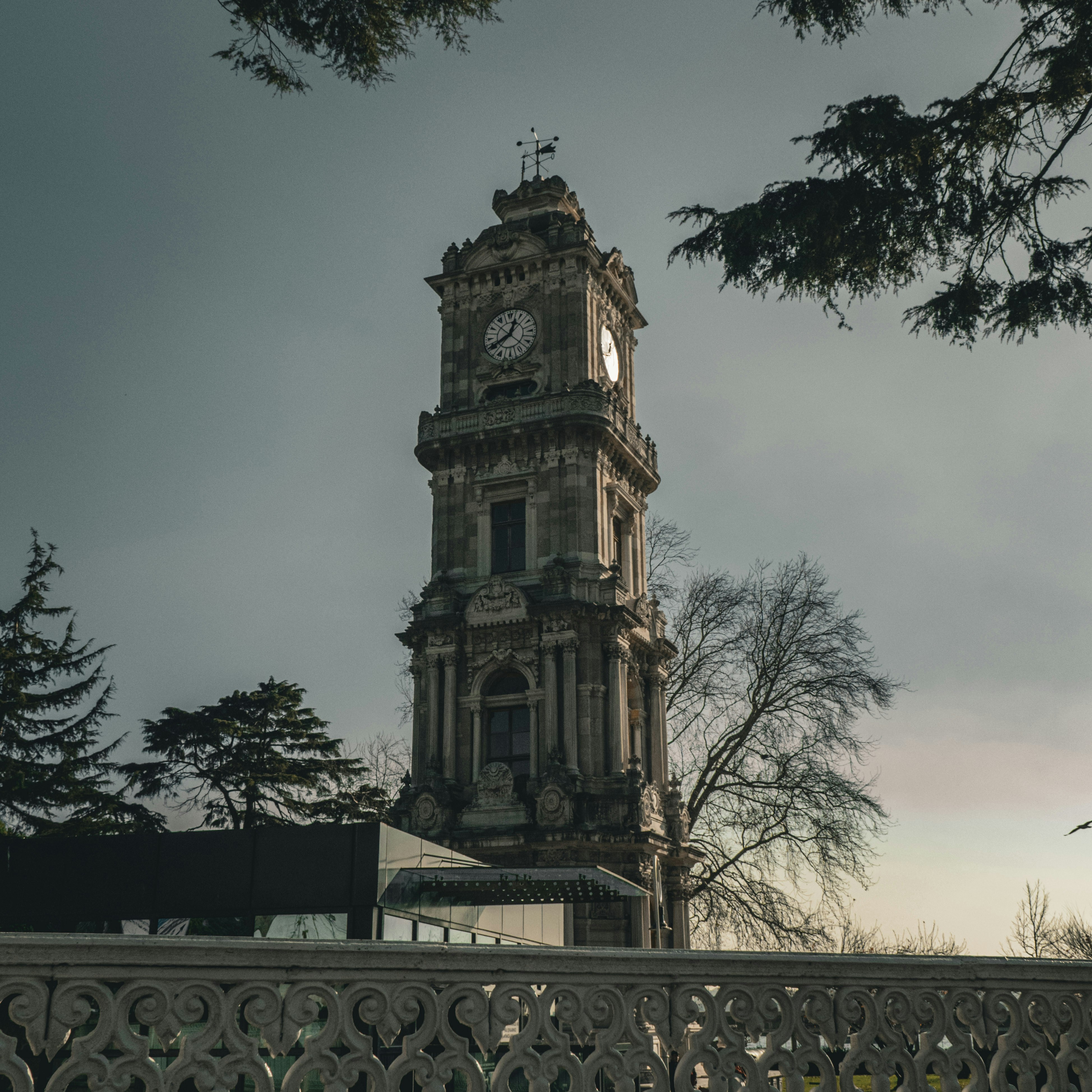 Timekeeper's Tower: Gothic Clocktower Framed by Carved Railings at Dusk