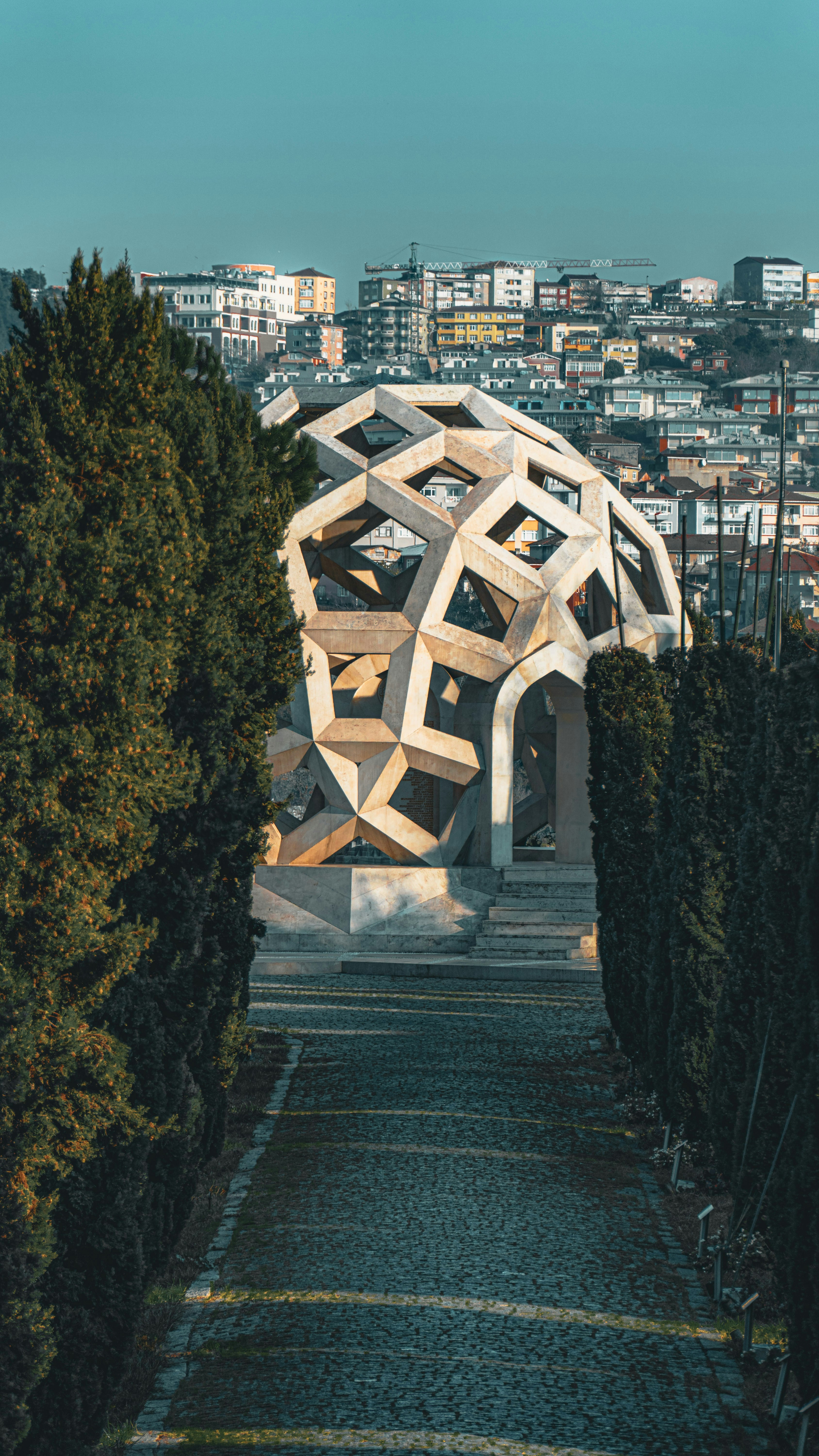Geodesic Dome Framed by Cedar-Tall Trees Along a Cobblestone Path