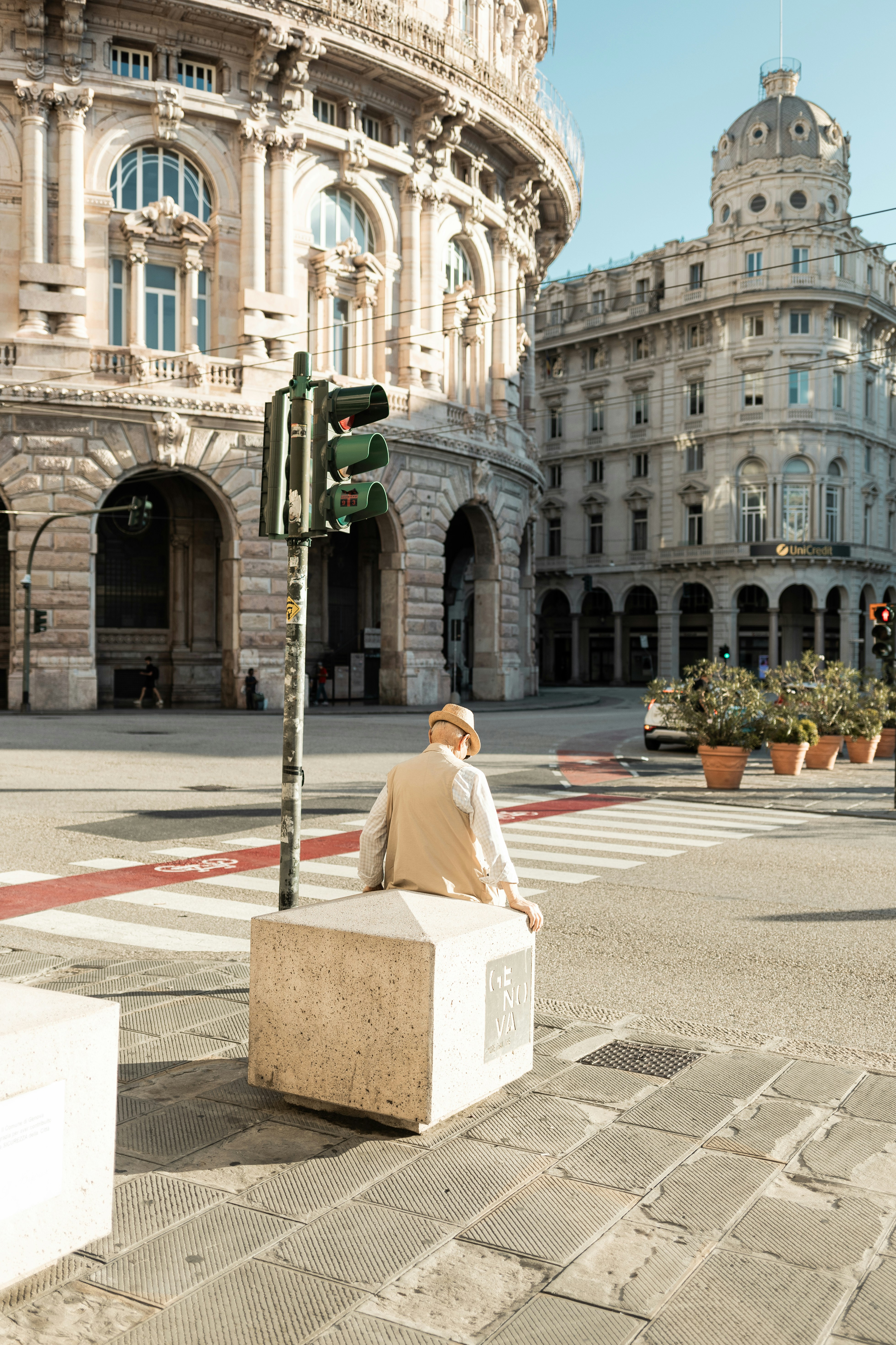 Una persona sentada en una cuadra frente a un edificio foto – Imagen de Genova gratuita en Unsplash