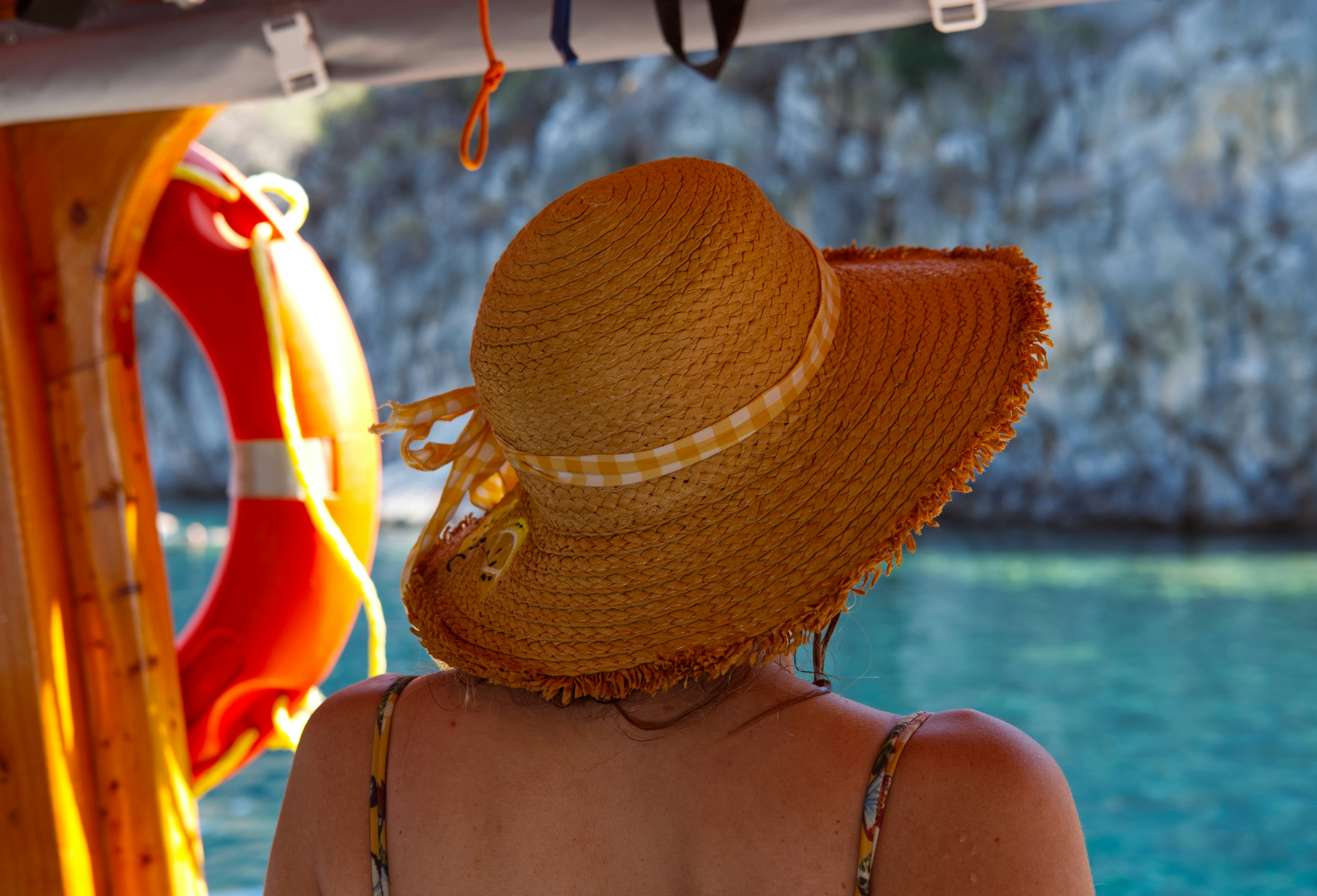 A woman in a straw hat sitting on a boat