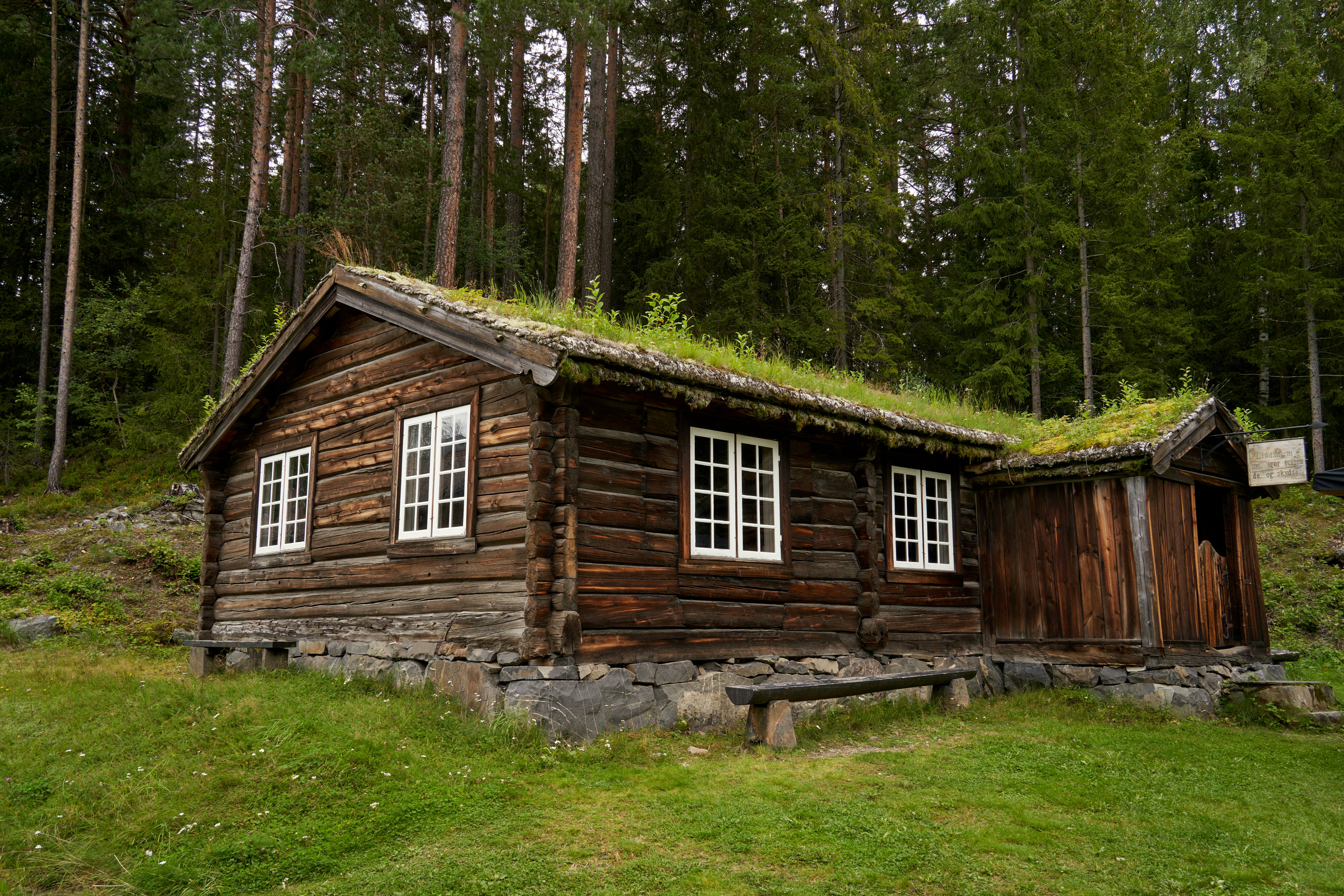 Very Old Simple Log House with a Grass-Covered Roof at Maihaugen Open-Air Museum in Lillehammer: A Glimpse into Traditional Norwegian Architecture and Rural Life