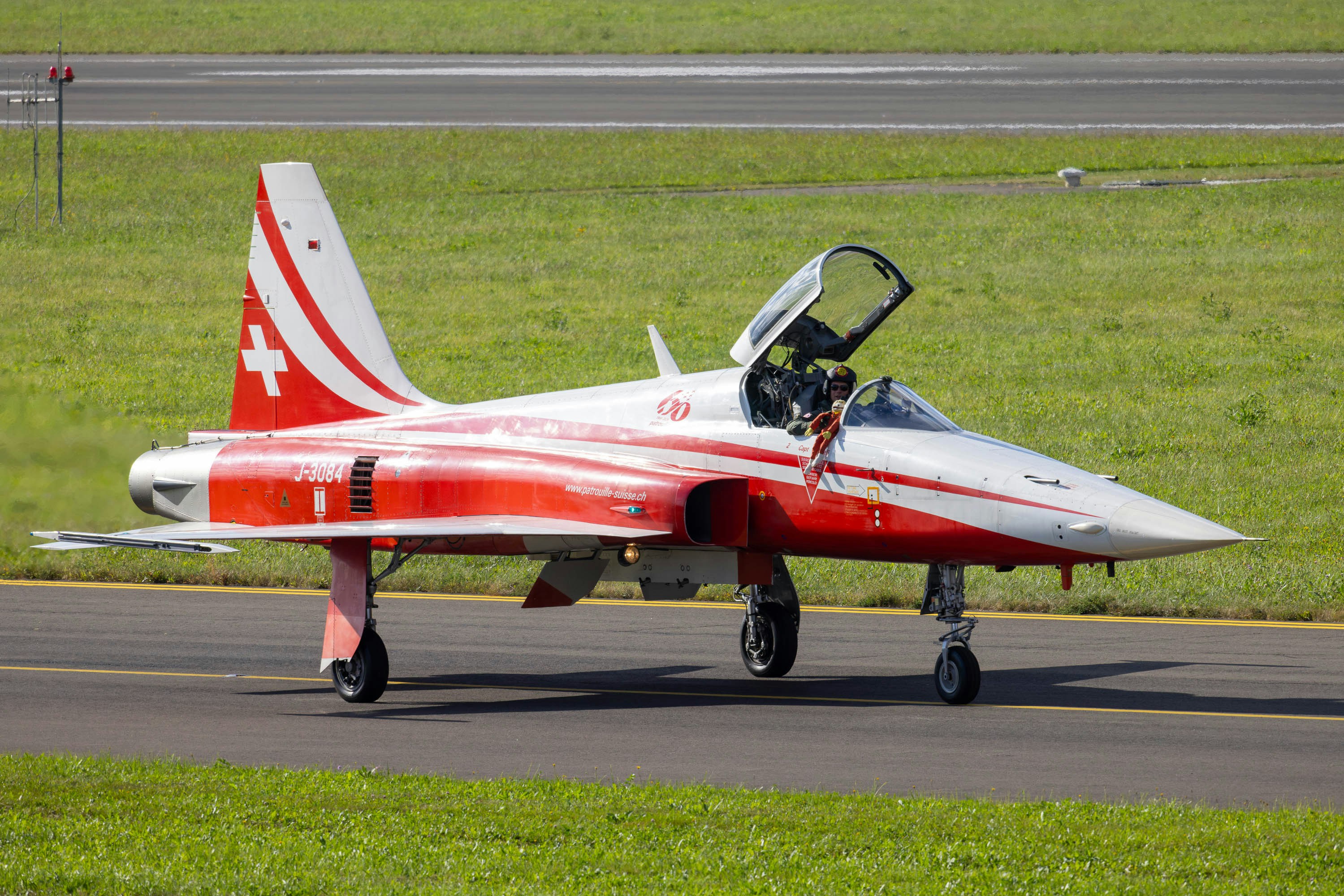 A red and white fighter jet on a runway photo – Free Zeltweg Image on ...