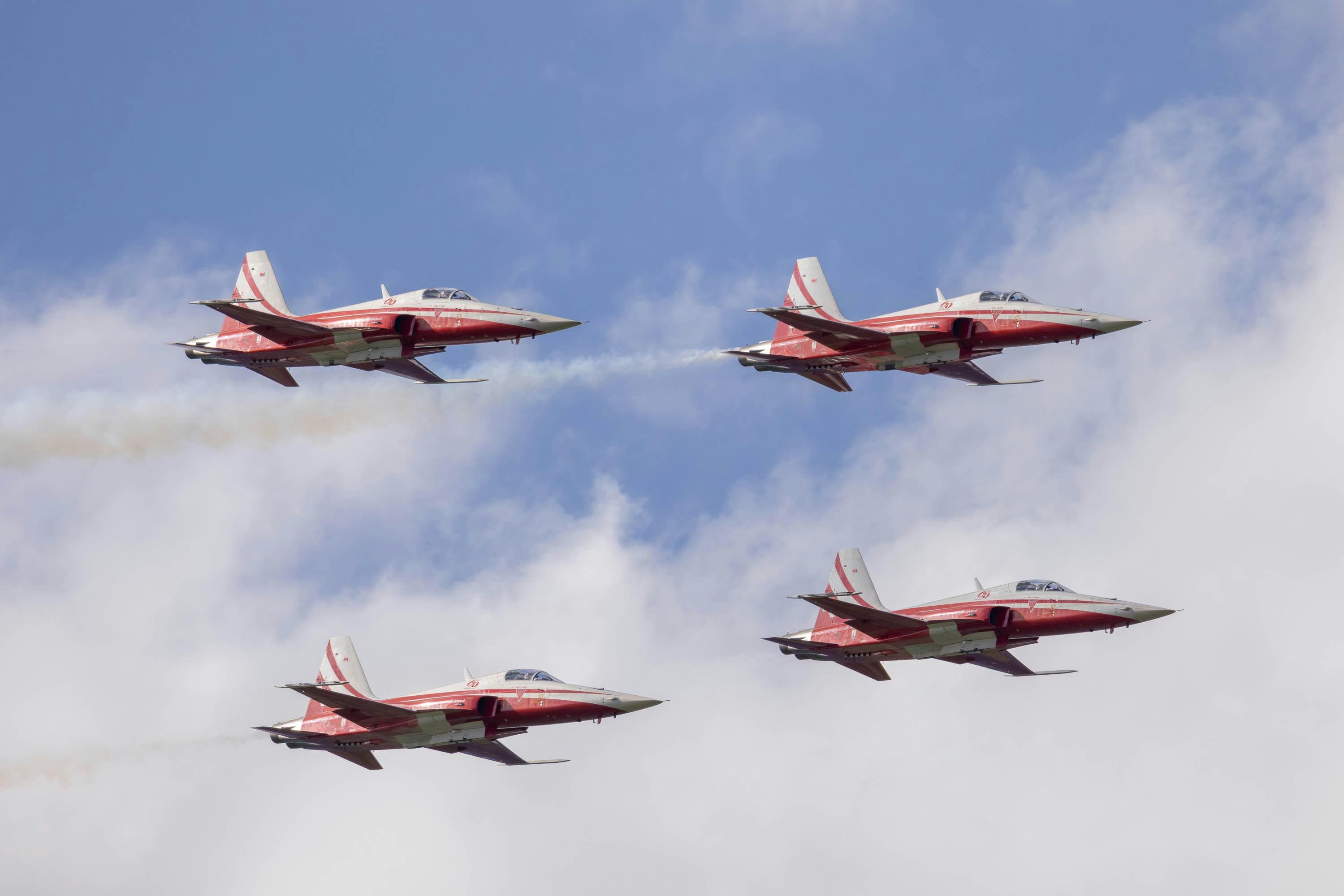 A group of fighter jets flying through a blue cloudy sky photo – Free ...