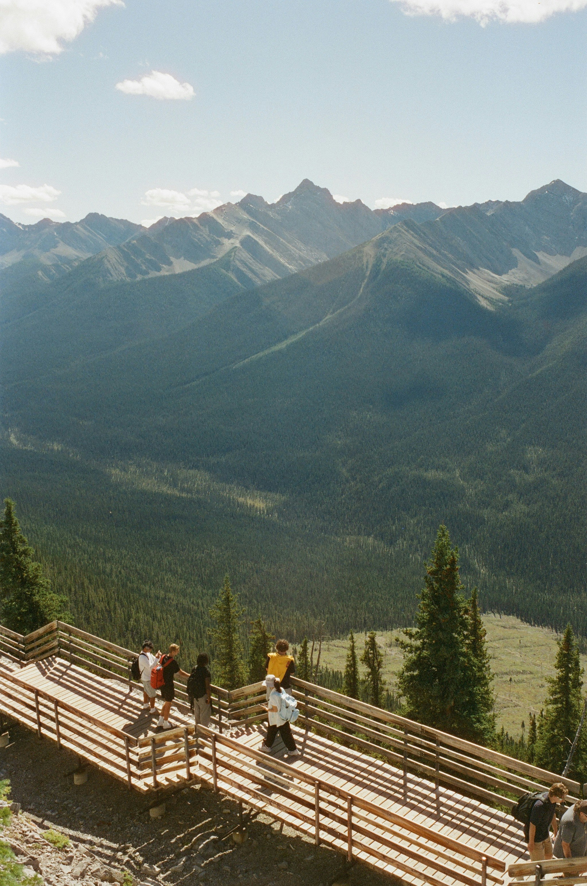 A group of people standing on top of a wooden bridge photo – Free Shot ...