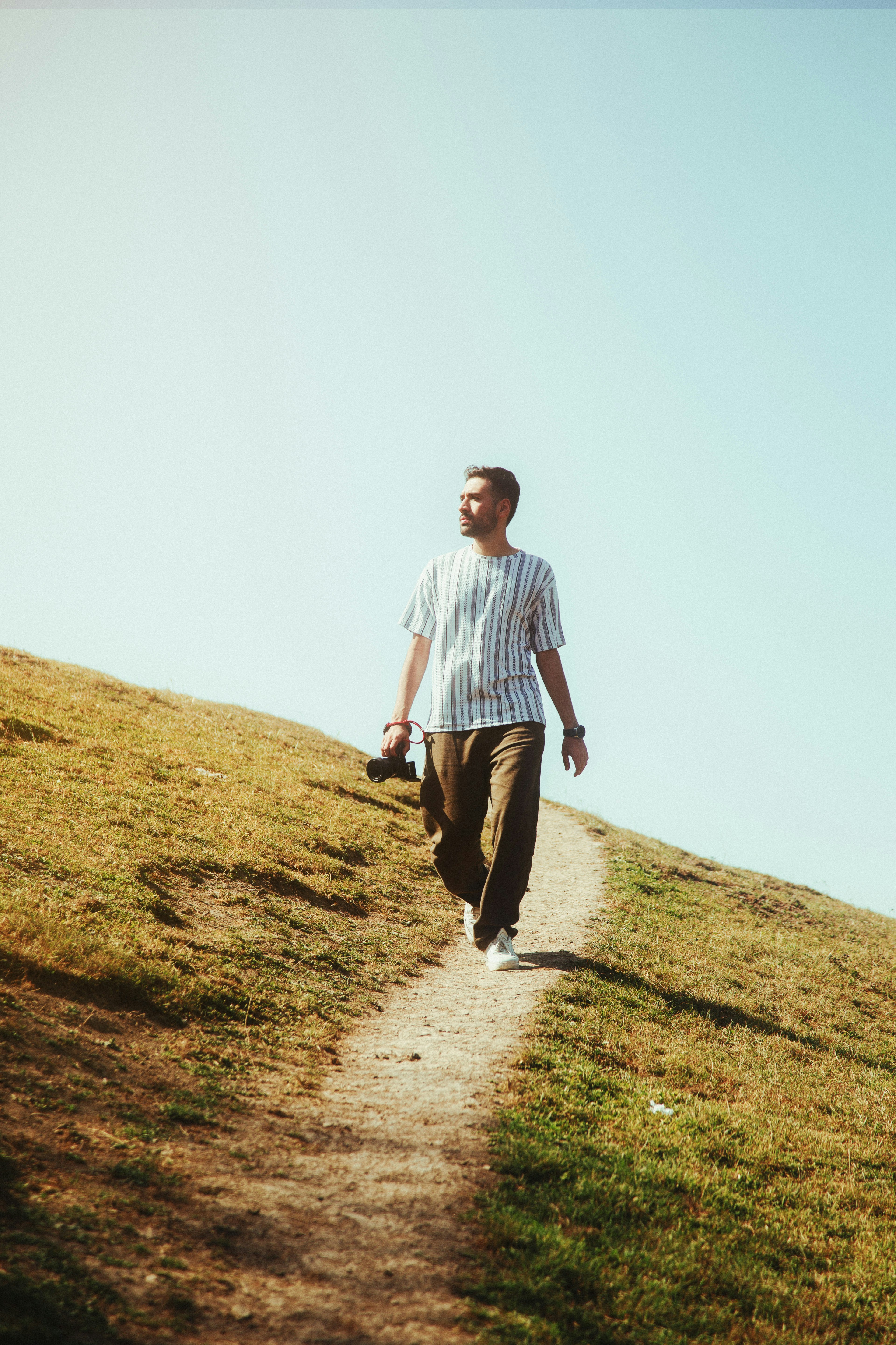 Stride With Scope: A Photographer on a Sunlit Hill