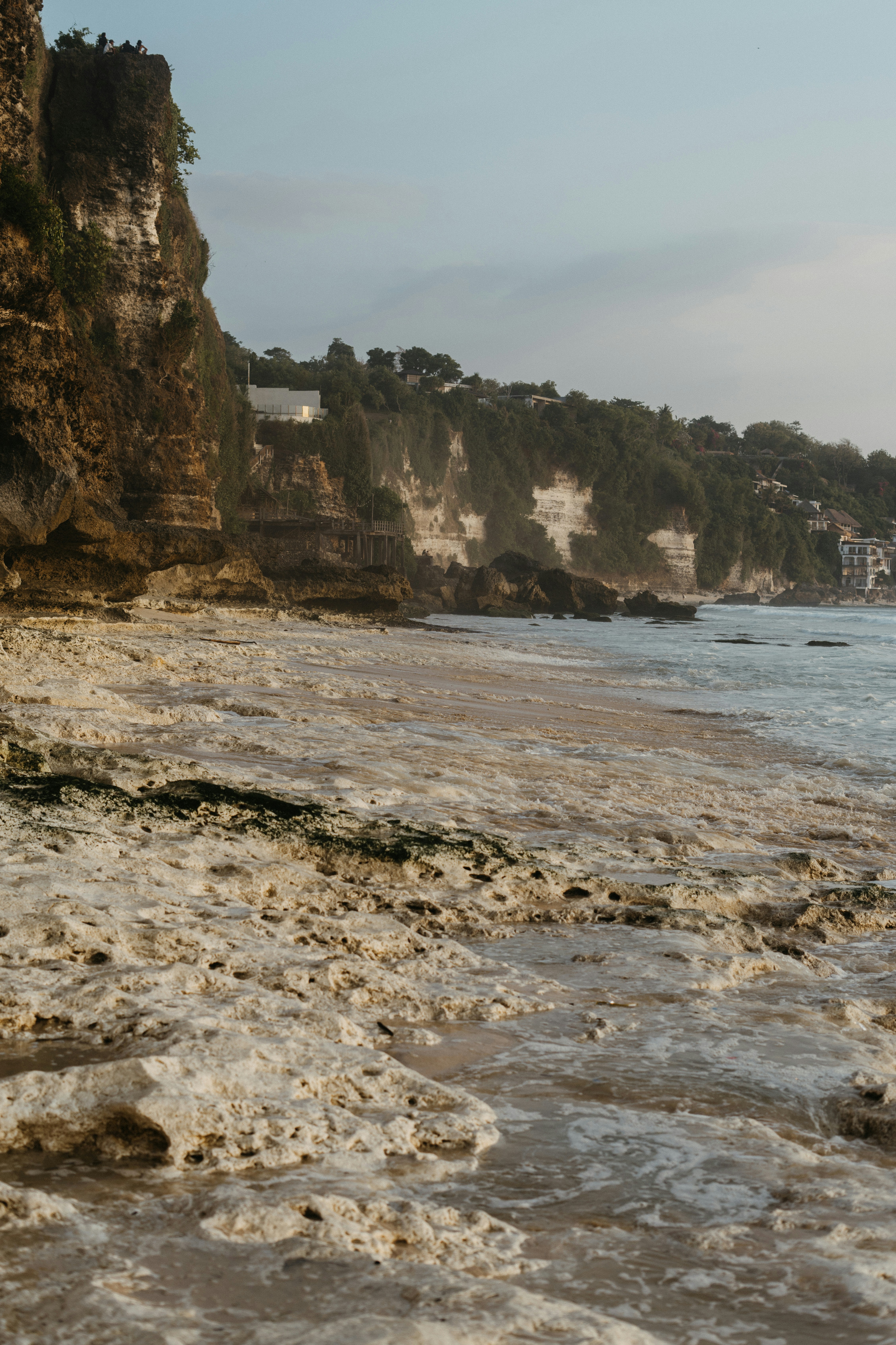 A rocky beach with a cliff in the background photo – Free Bali Image on ...