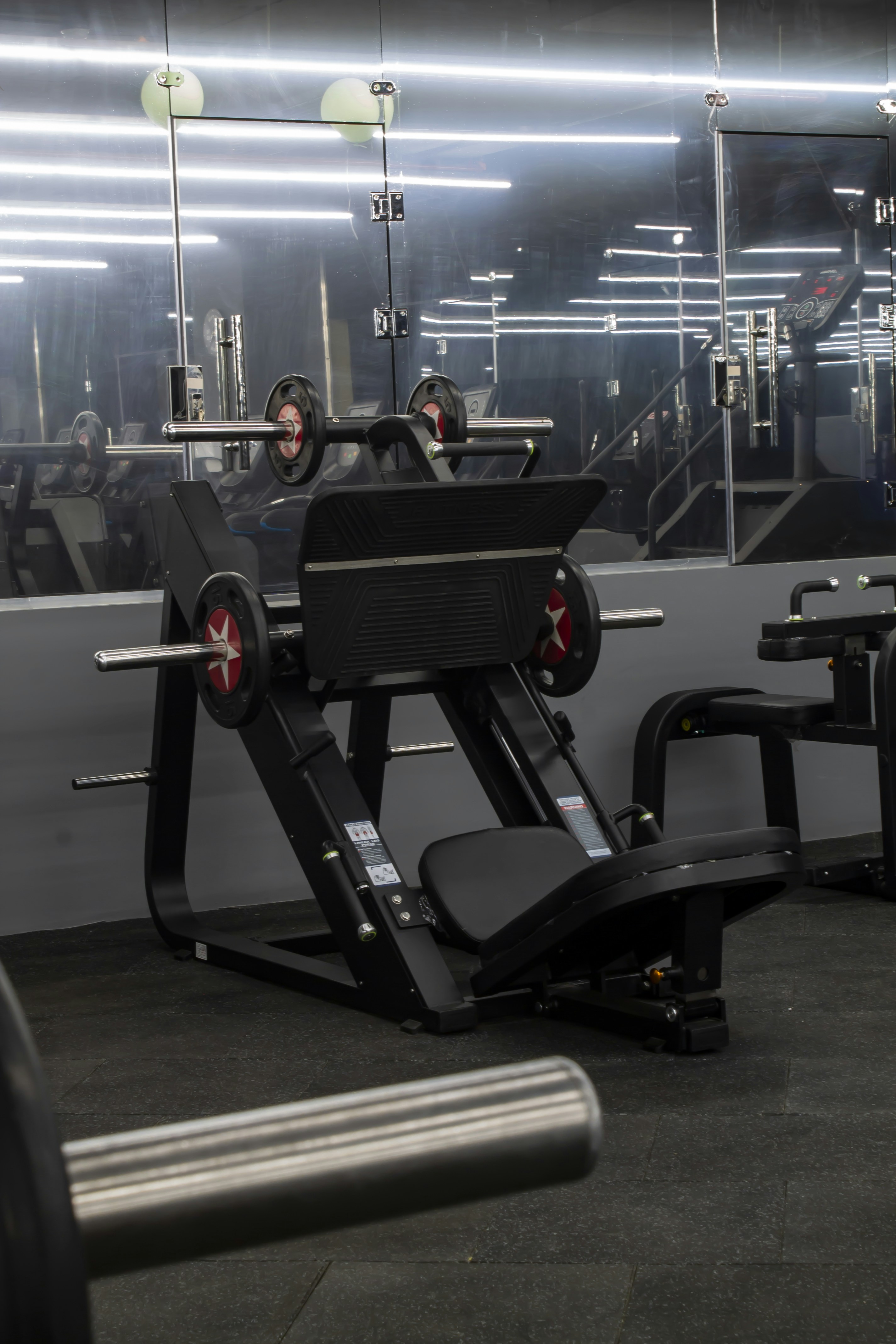 A gym filled with machines and weight plates photo – Free Exercise ...