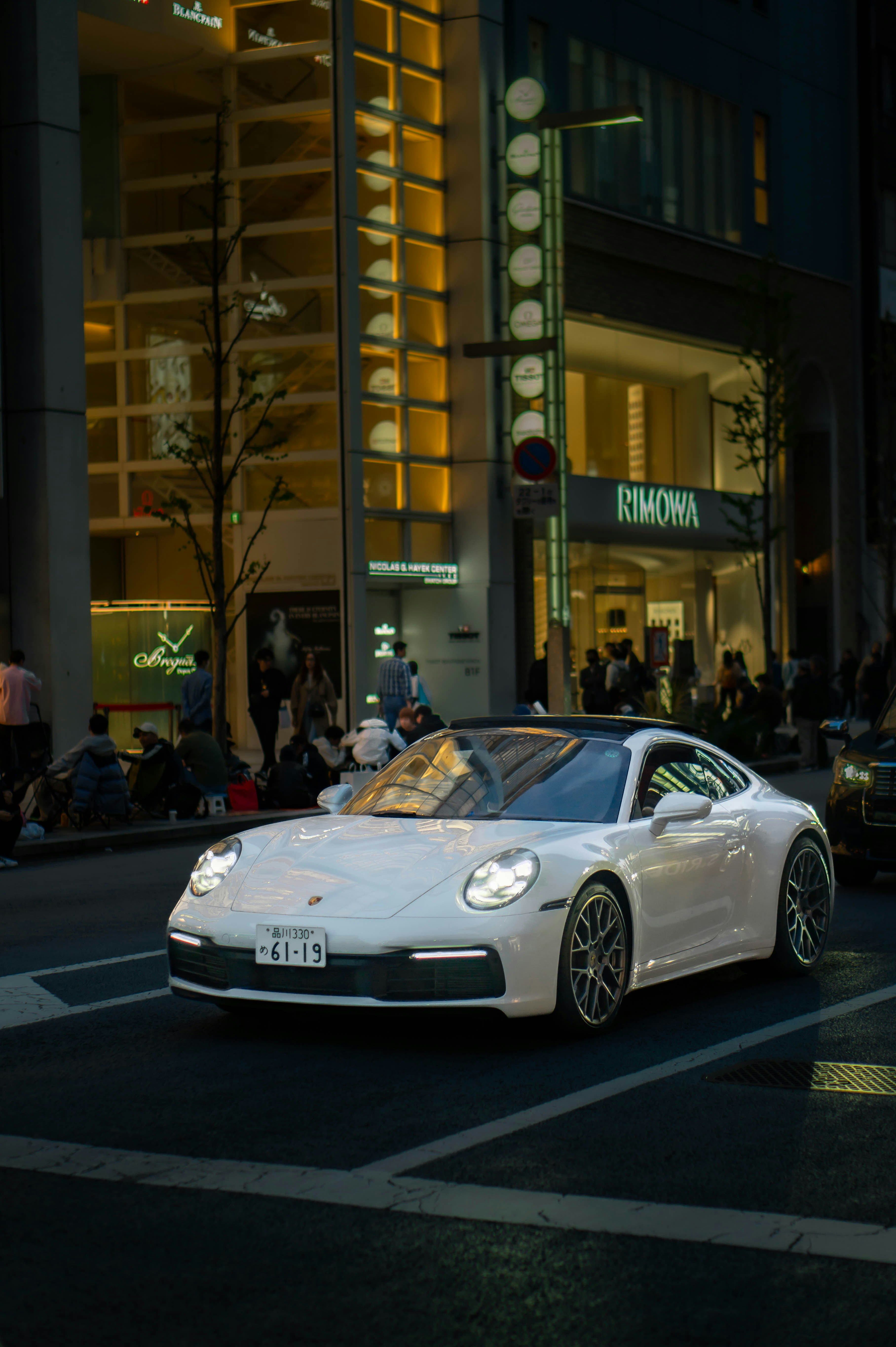 Neon-Bathed Night: White Porsche on a Bustling Tokyo Street