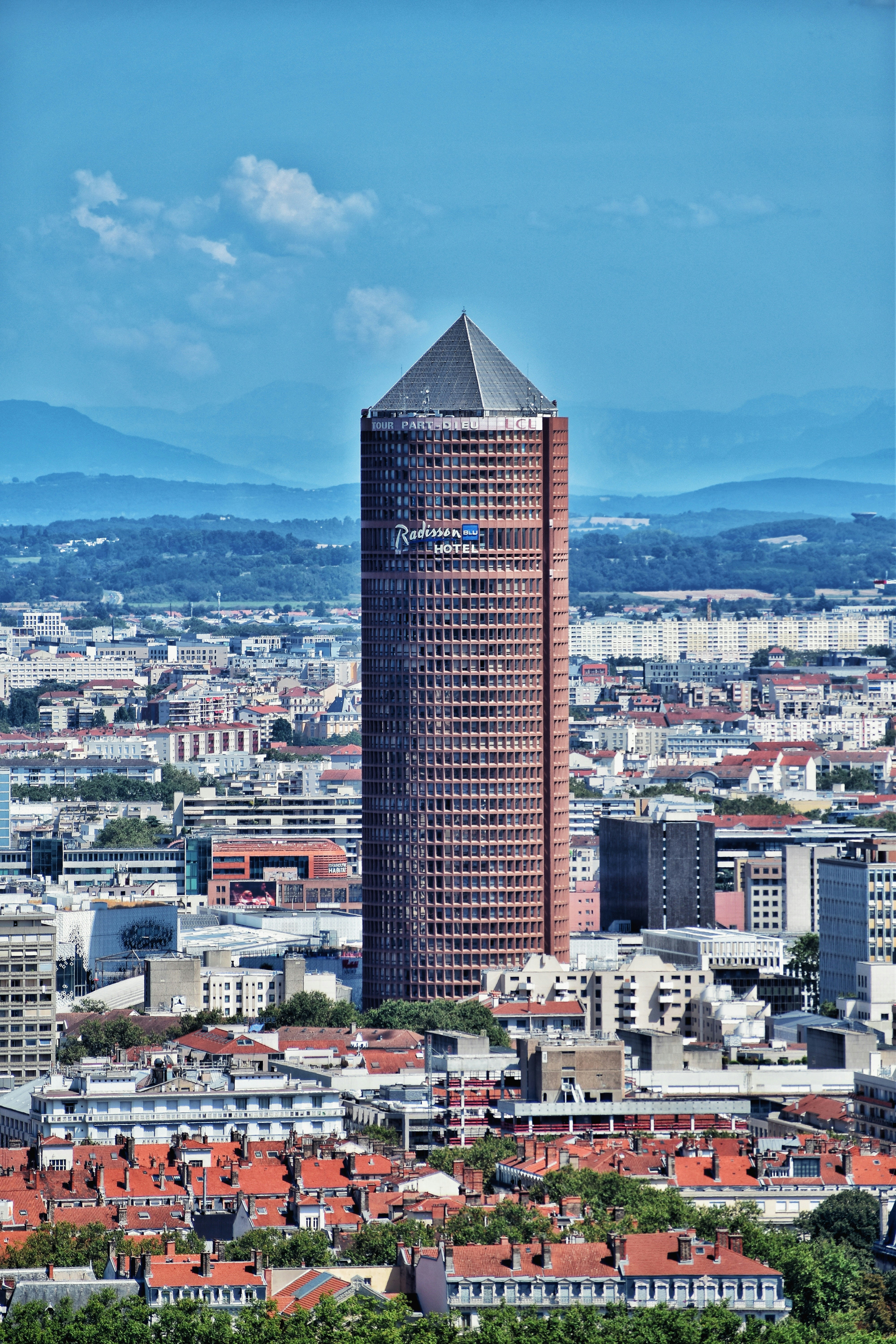Urban Pinnacle: The Radisson Tower Against a Scenic Backdrop