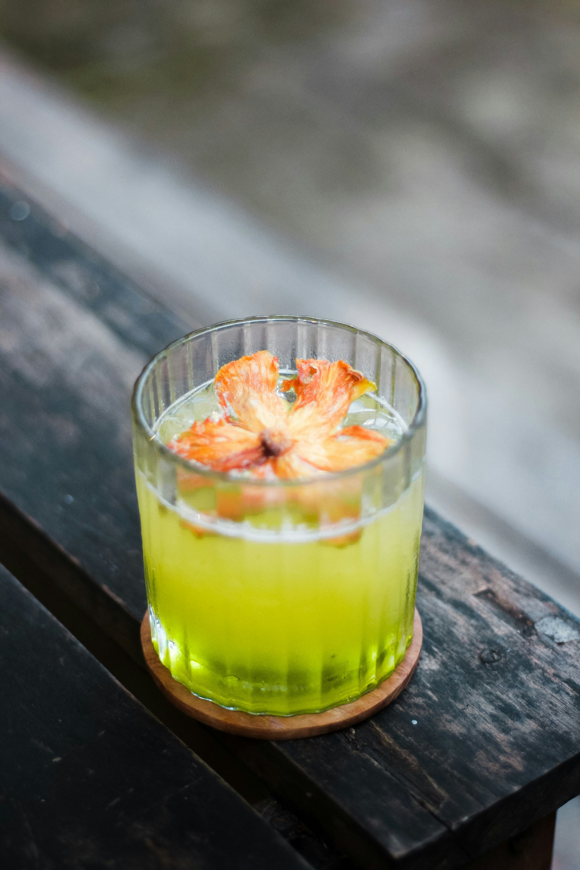 Emerald Cocktail on Weathered Wood, Crowned with a Citrus Flower