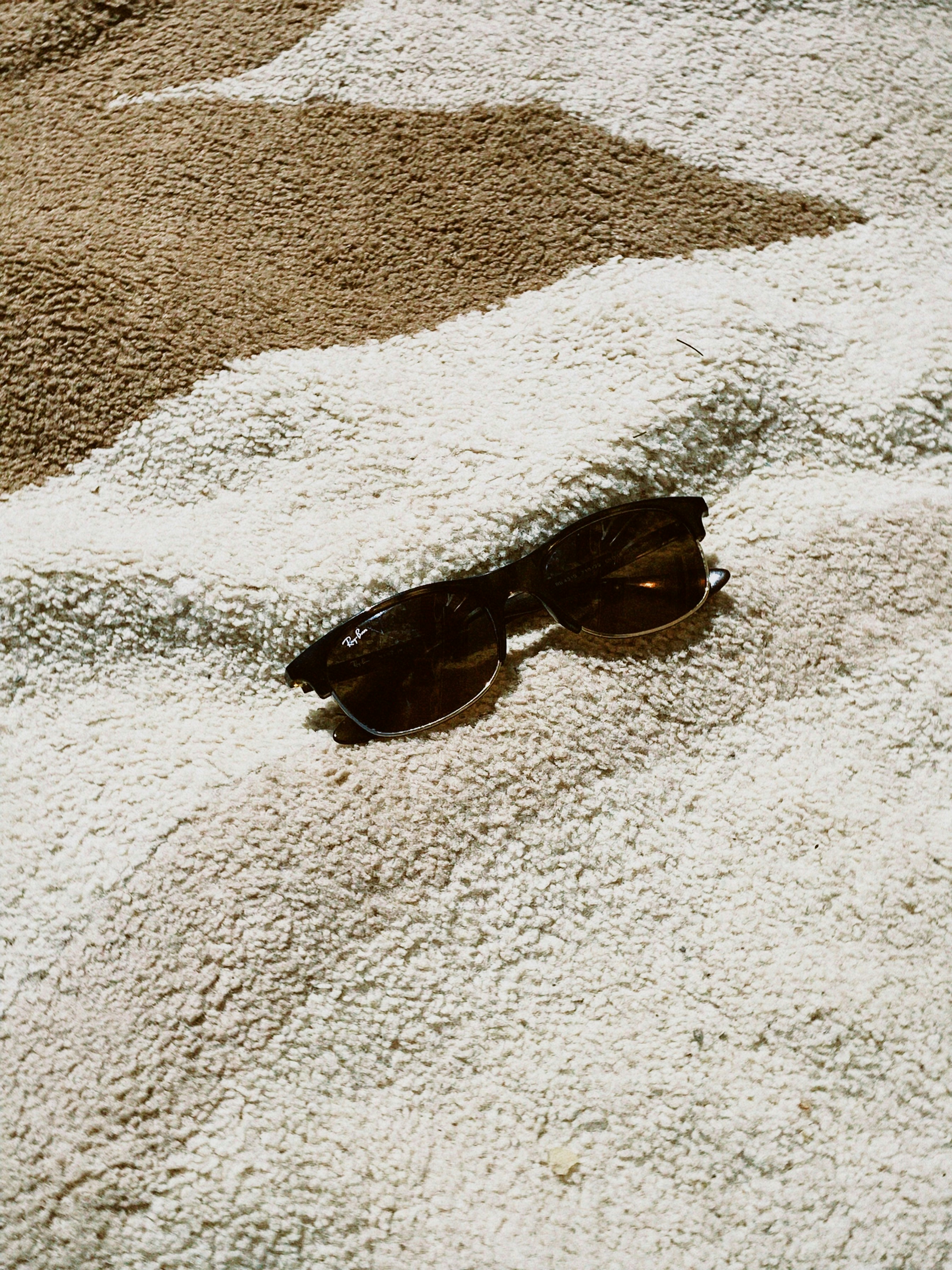 Shadowed Sunglasses Rest on Dunes of Sunlit Sand