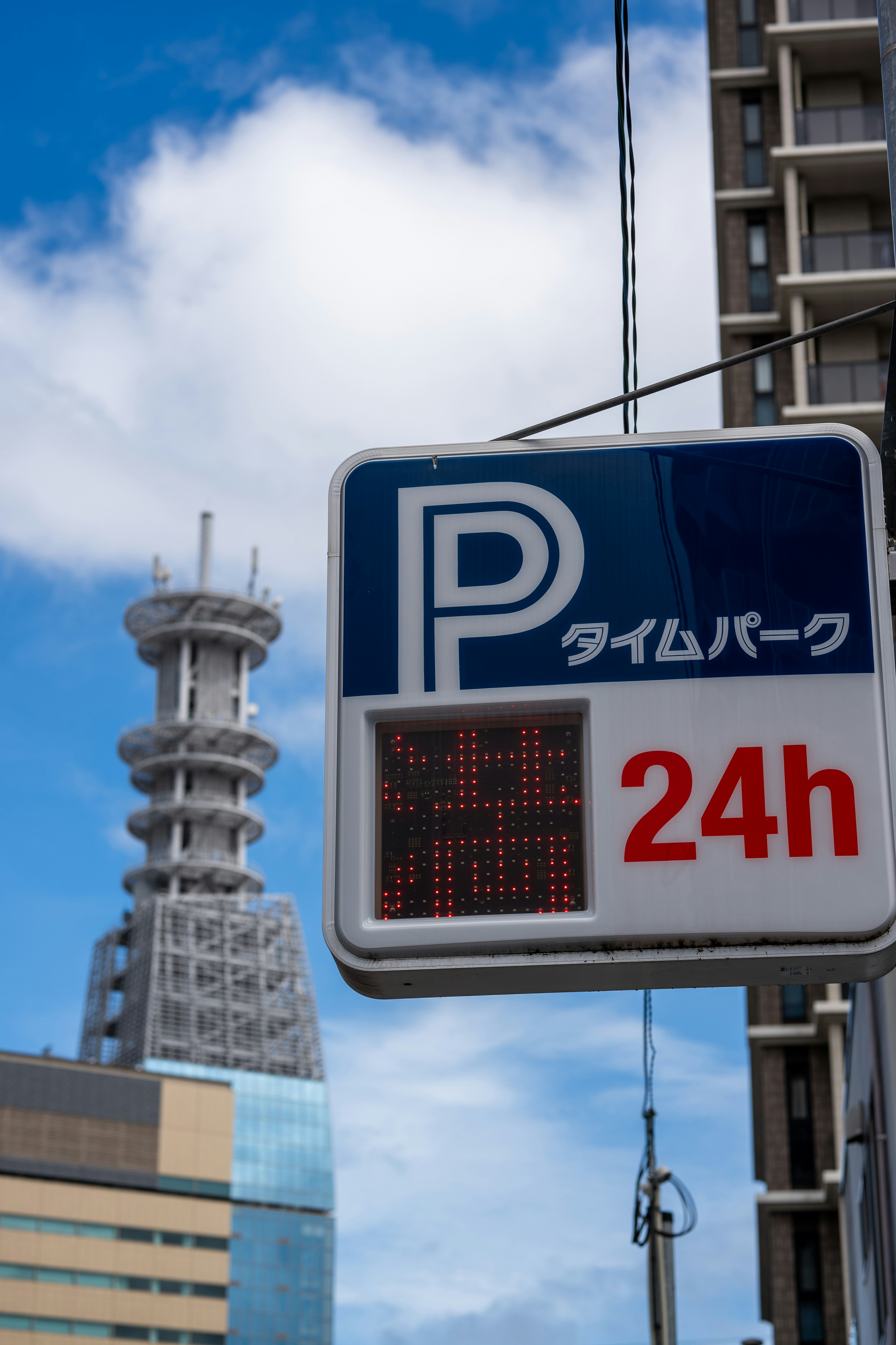 A parking sign in front of a tall building photo – Free Electronics ...