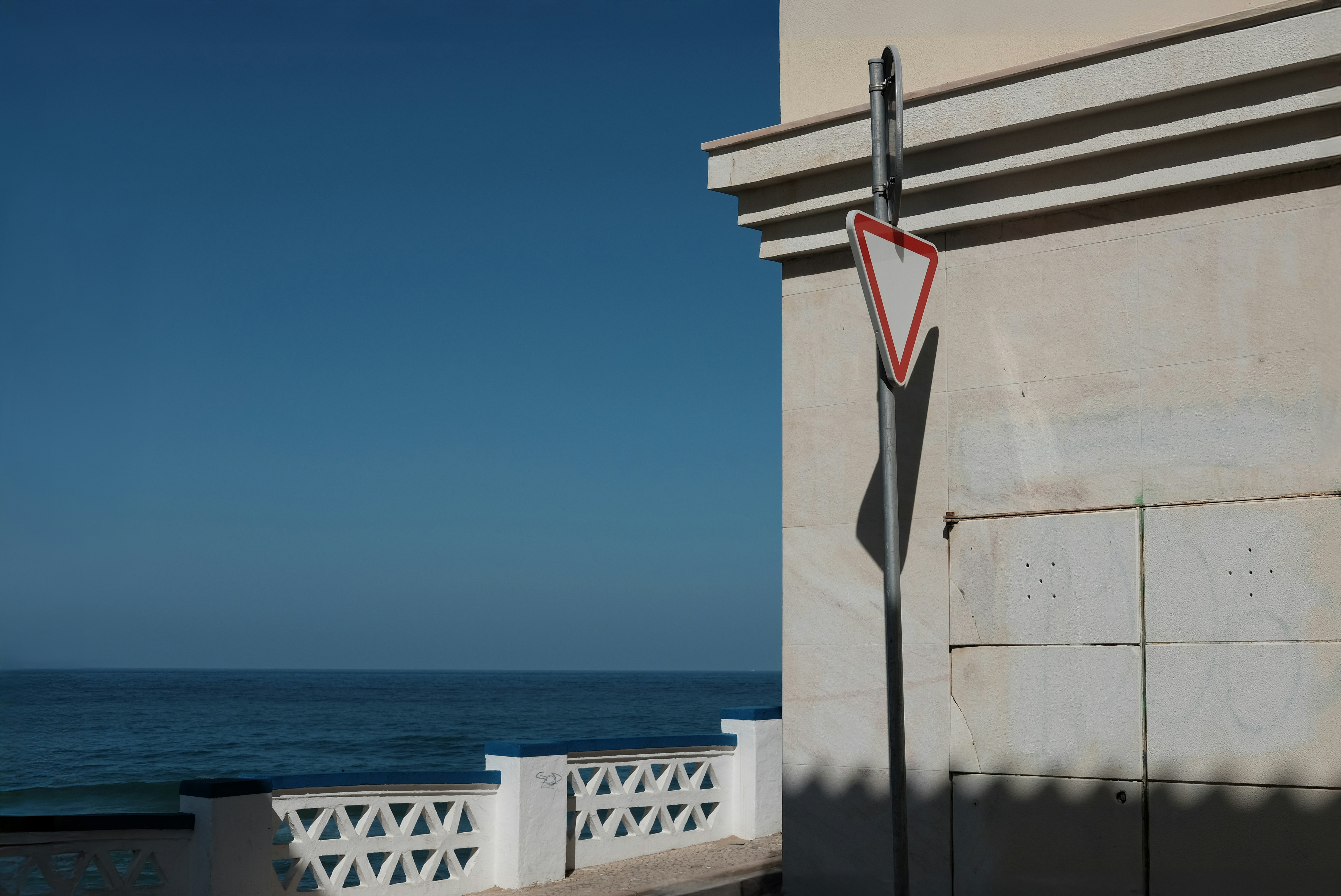 A street sign on the side of a building next to the ocean photo – Free ...