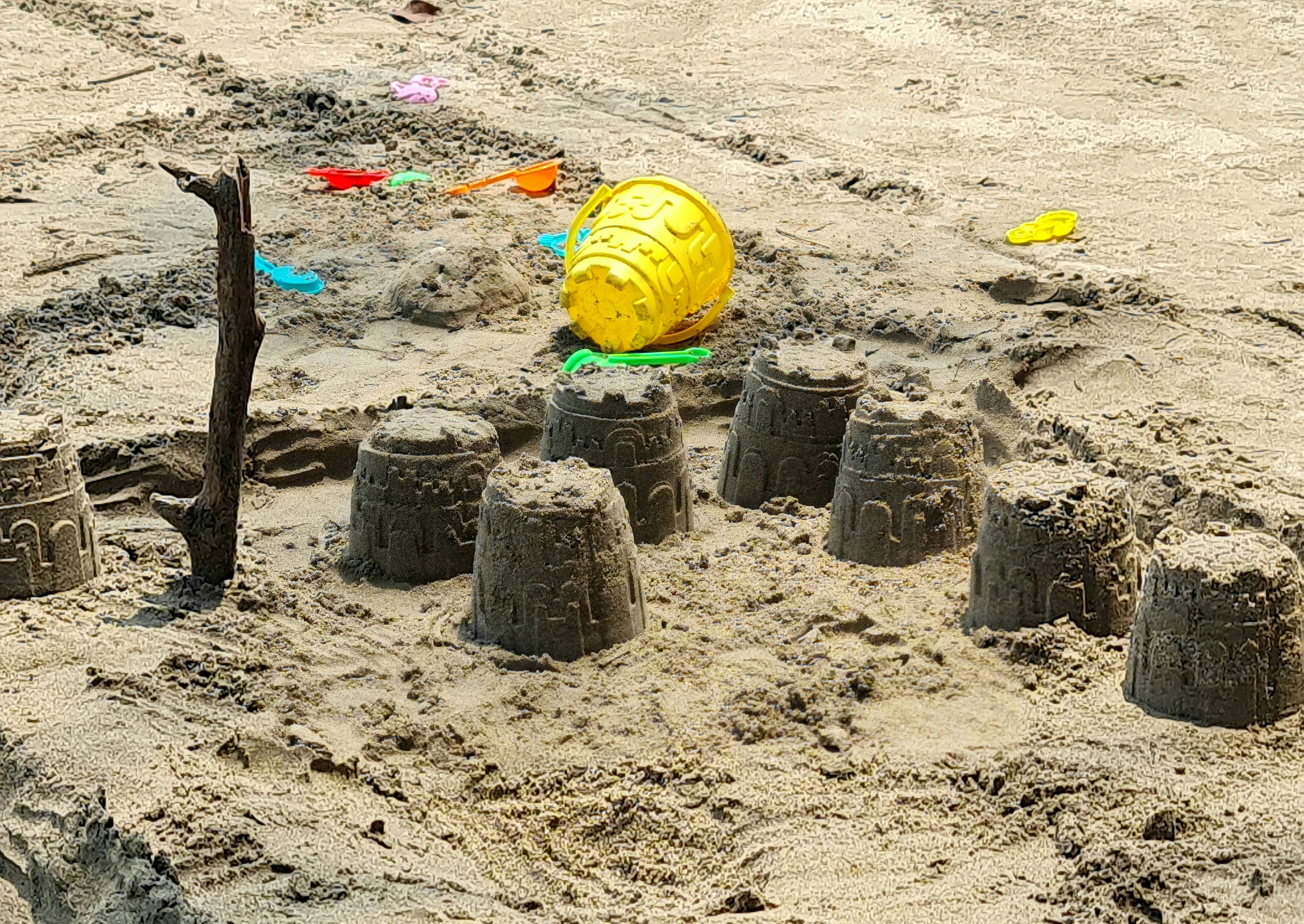 A sand castle made of sand with a yellow ball in the middle photo – Free Beach Image on Unsplash
