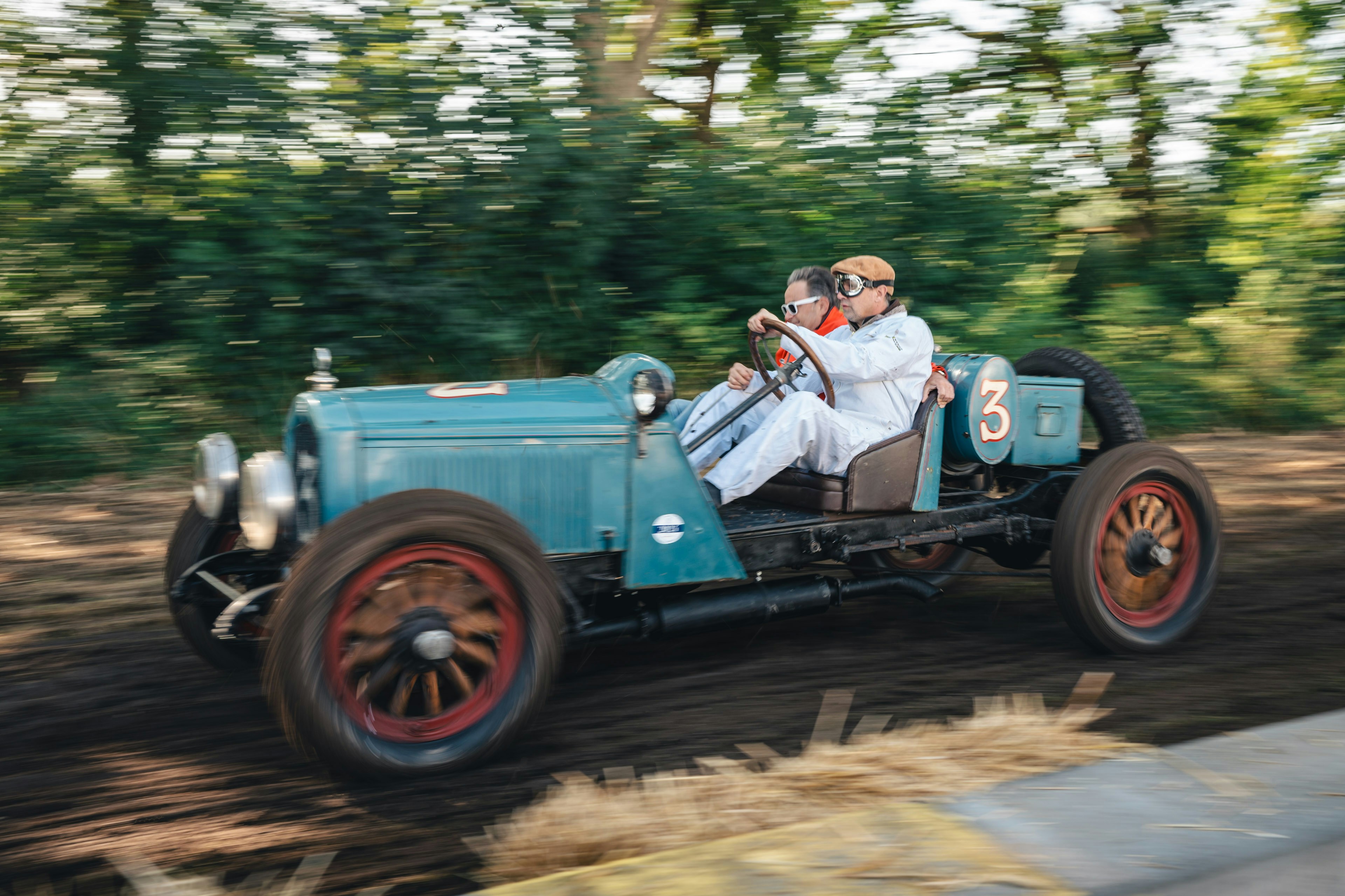 Vintage racer in motion: blue open-top car hurtling along a track
