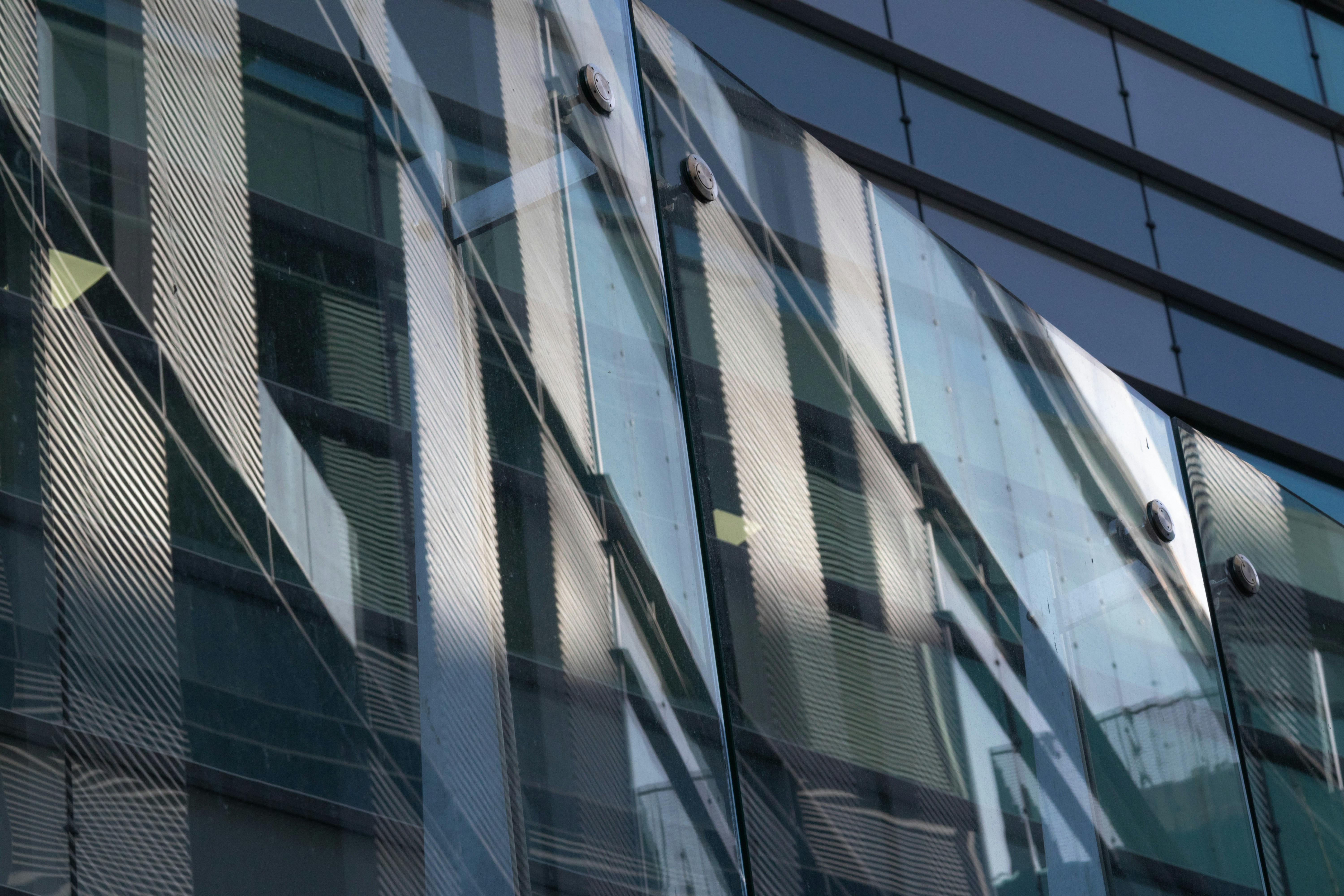 Modern building facade with reflective glass panels creating abstract patterns.