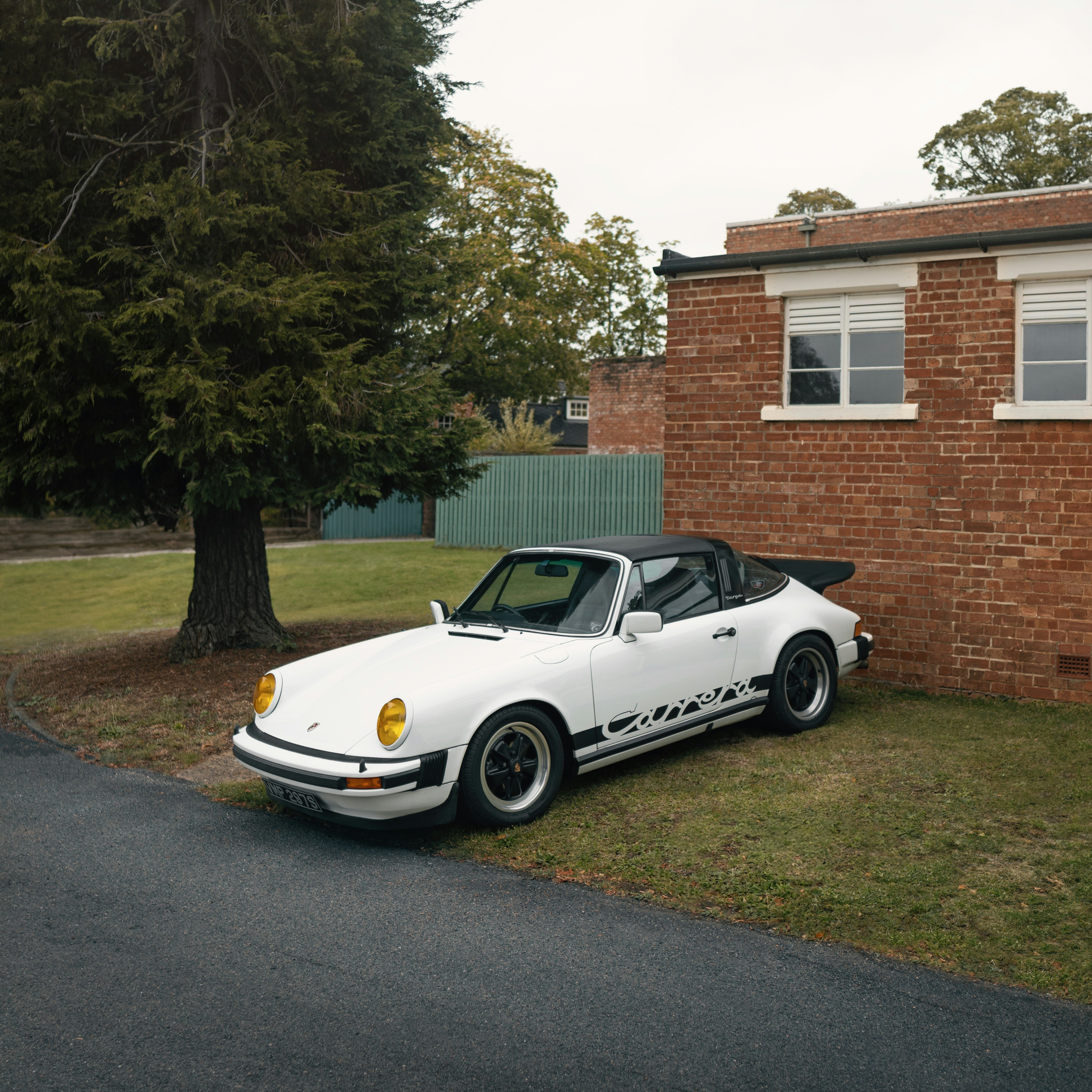 A white sports car parked in front of a brick house photo – Free ...