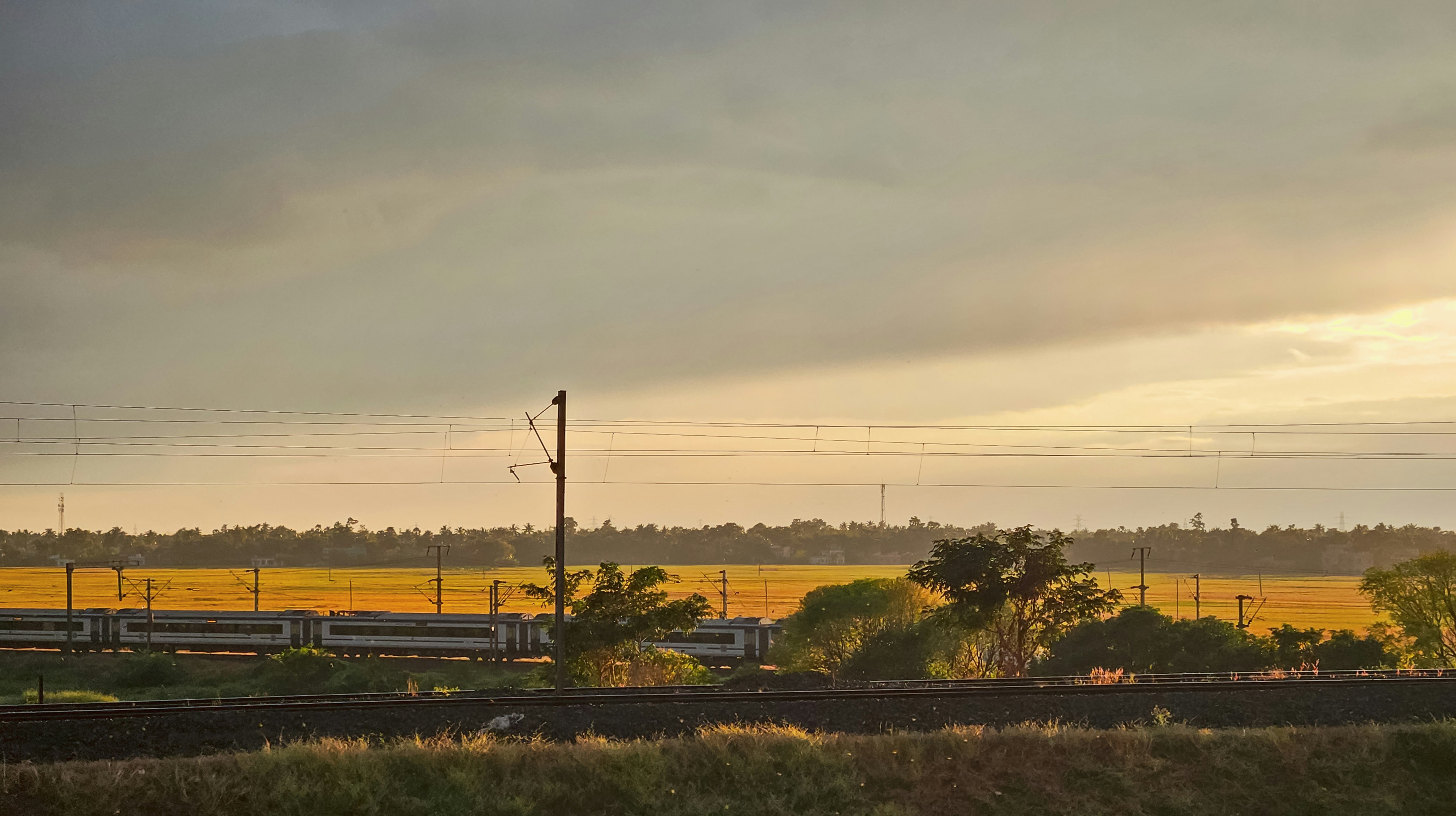Dusk Over Rails: A Lone Pole Against the Golden Horizon