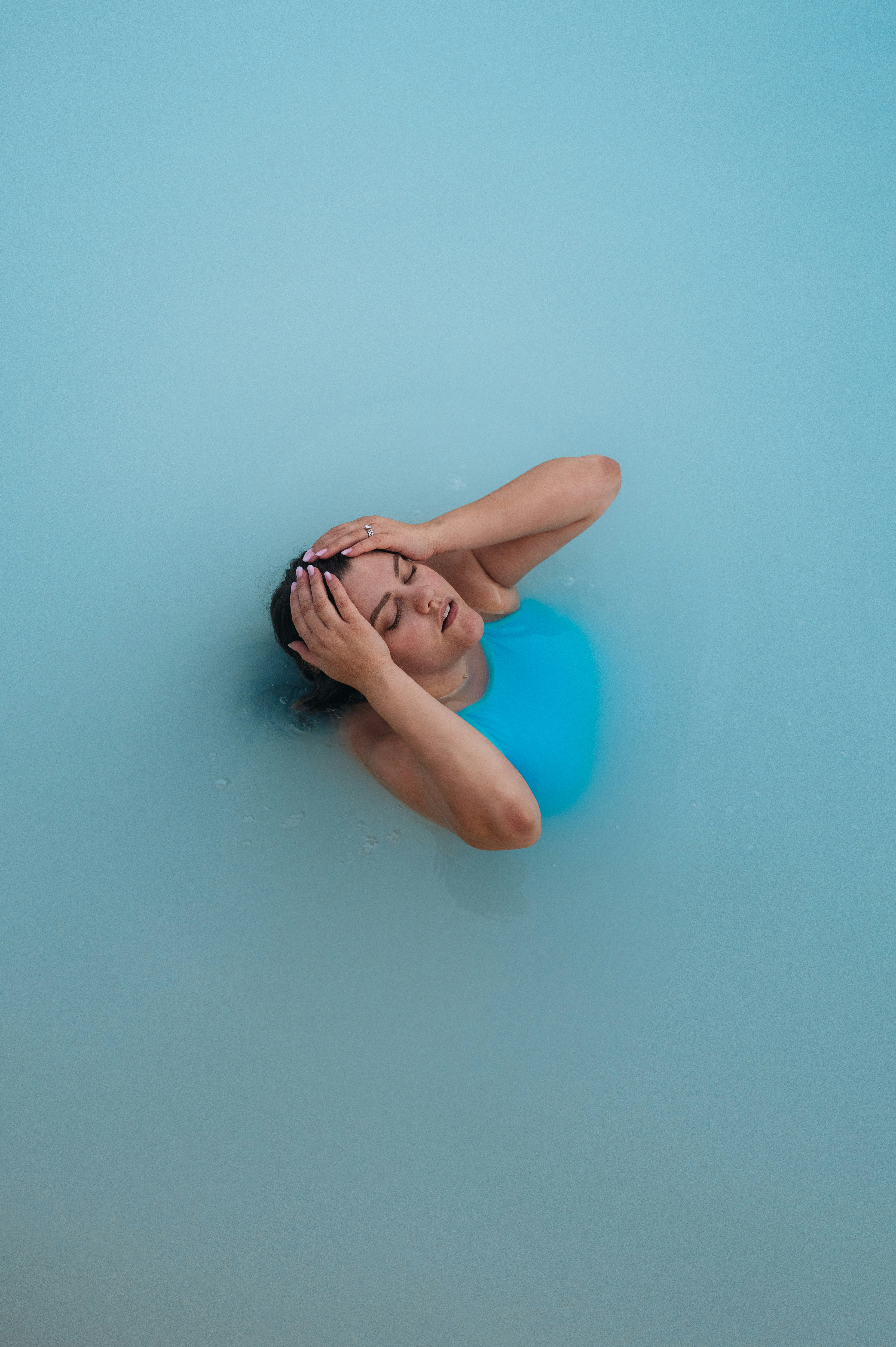 A woman is floating in a blue pool photo – Free Blue lagoon Image on ...