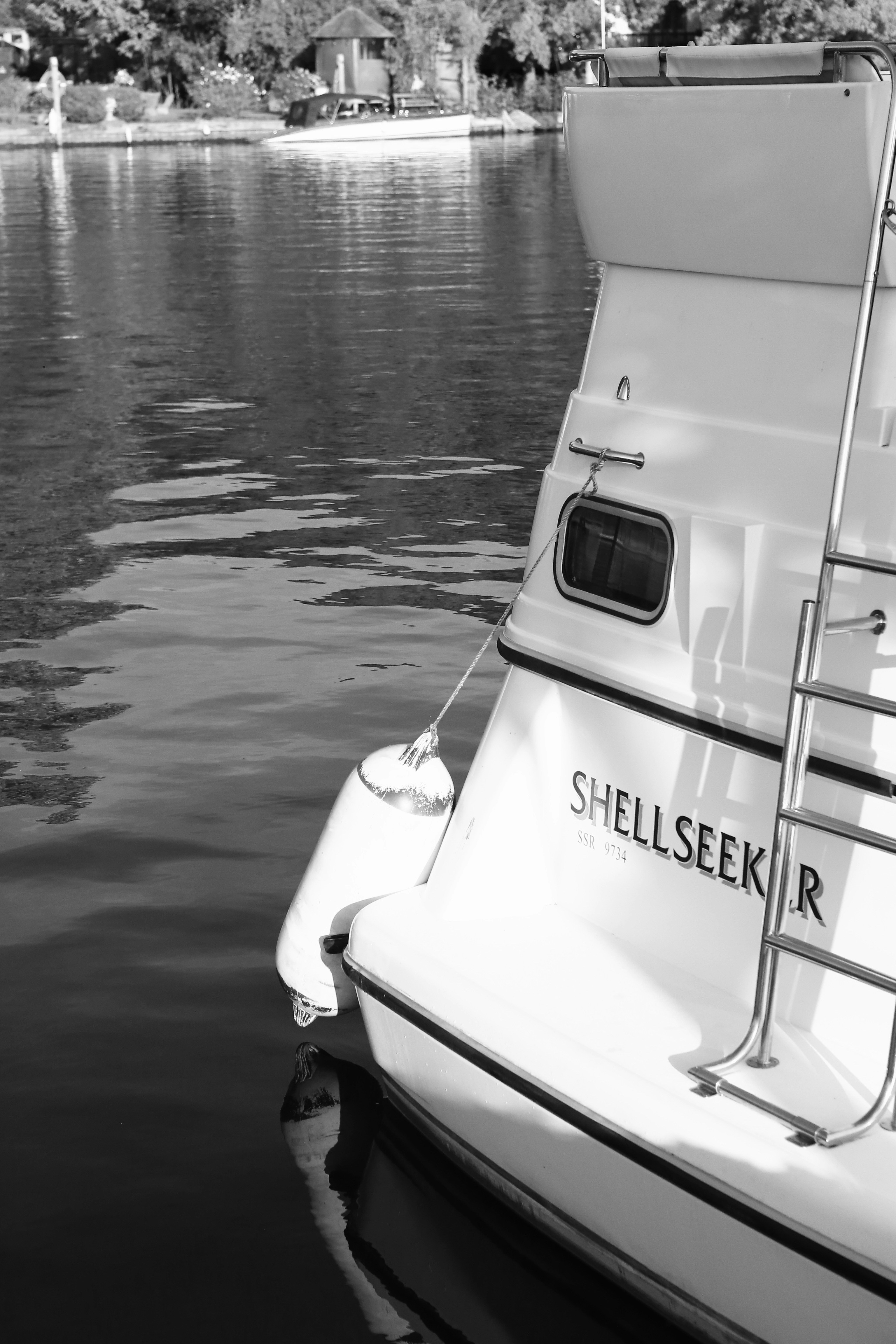 A small white boat floating on top of a lake photo – Free Boat Image on ...