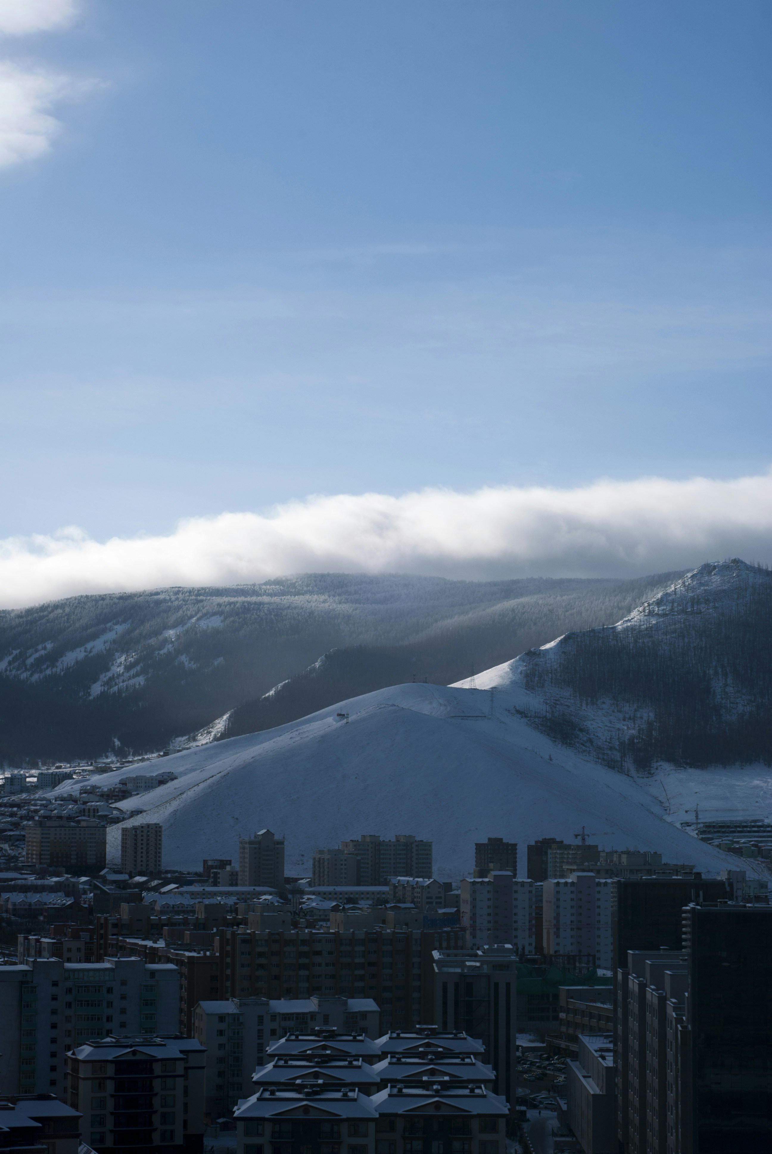 Snowy Ridge Over a Quiet Cityscape