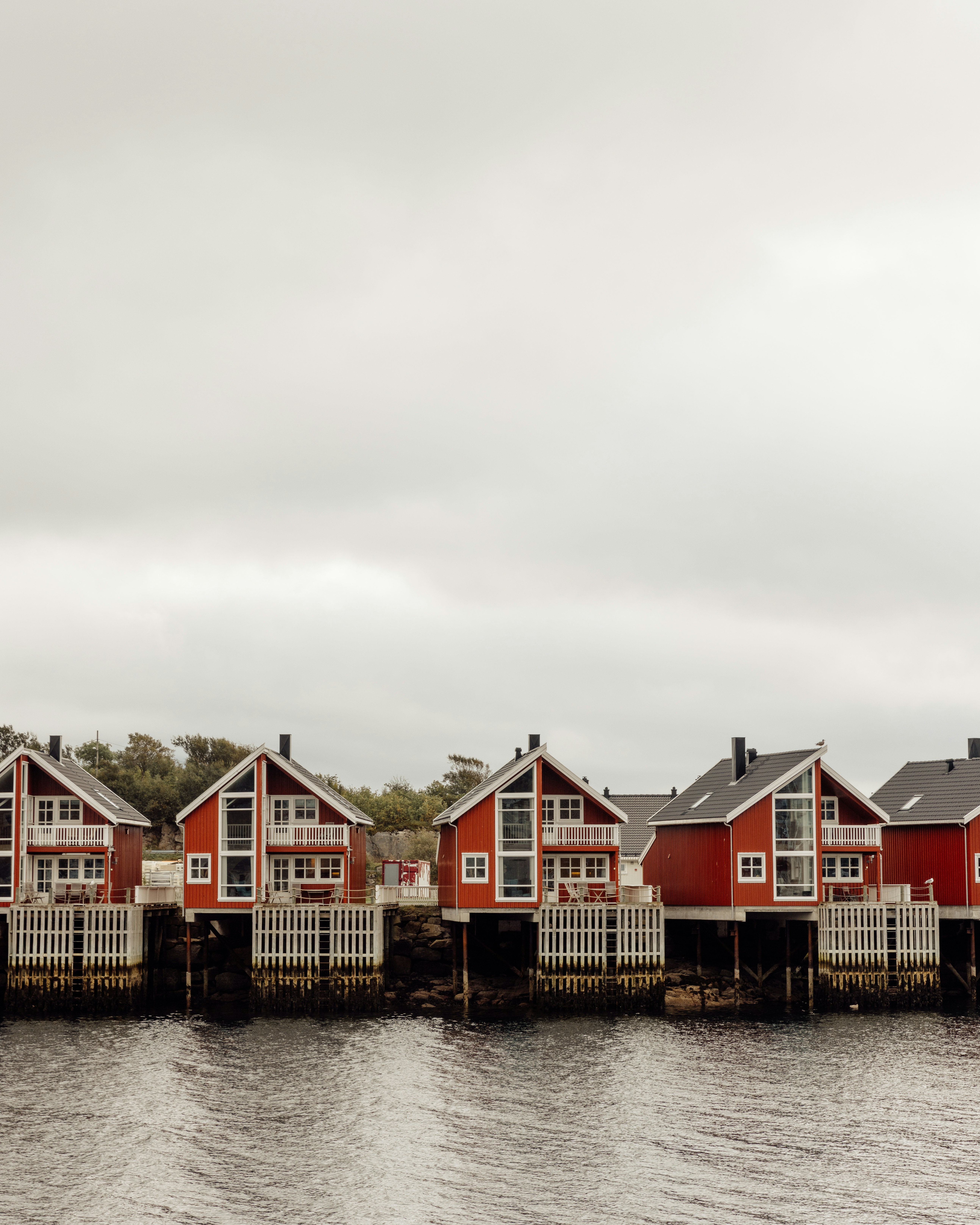 A row of red houses sitting next to a body of water photo – Free ...