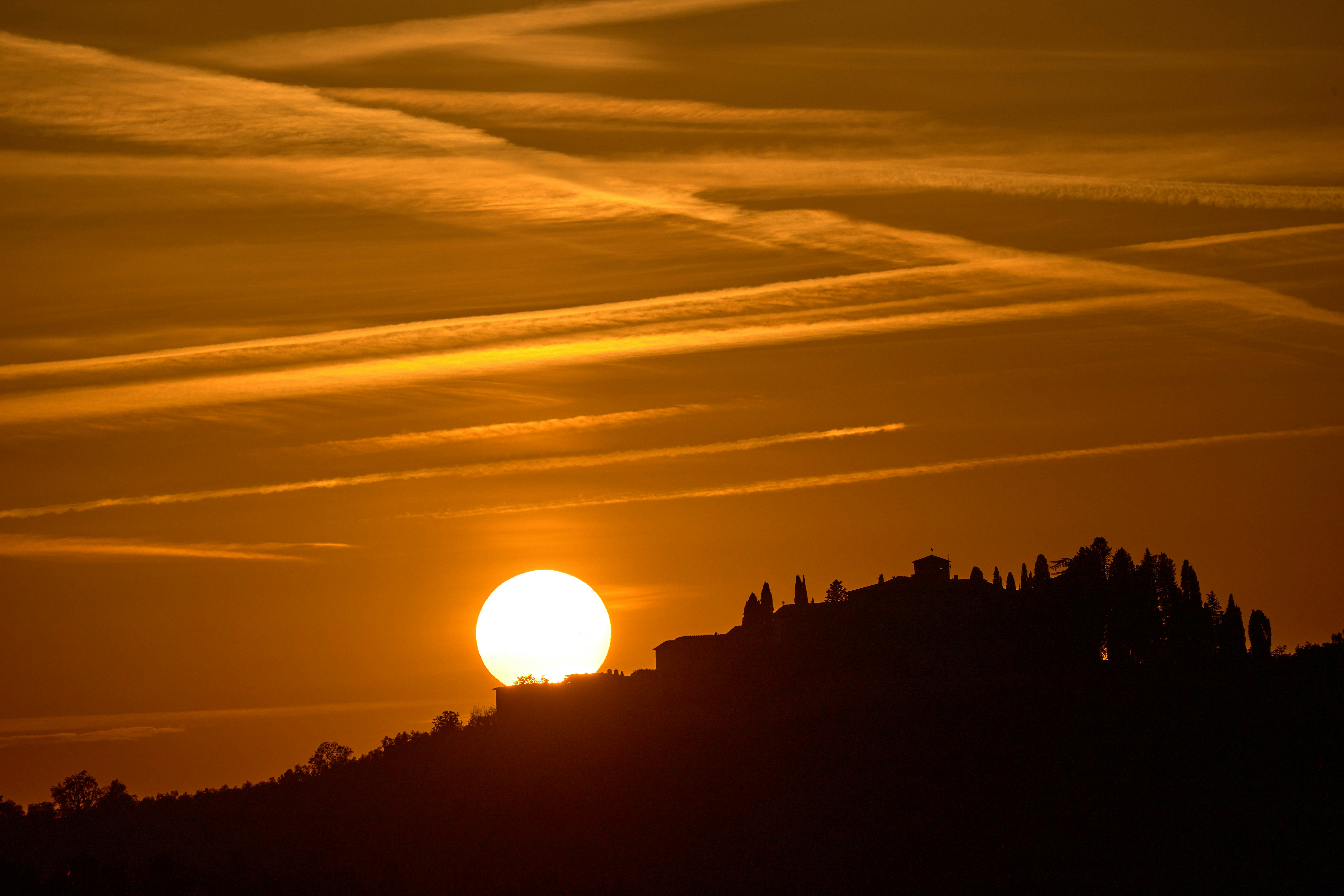 The sun is setting over a hill with trees photo – Free Nature Image on ...