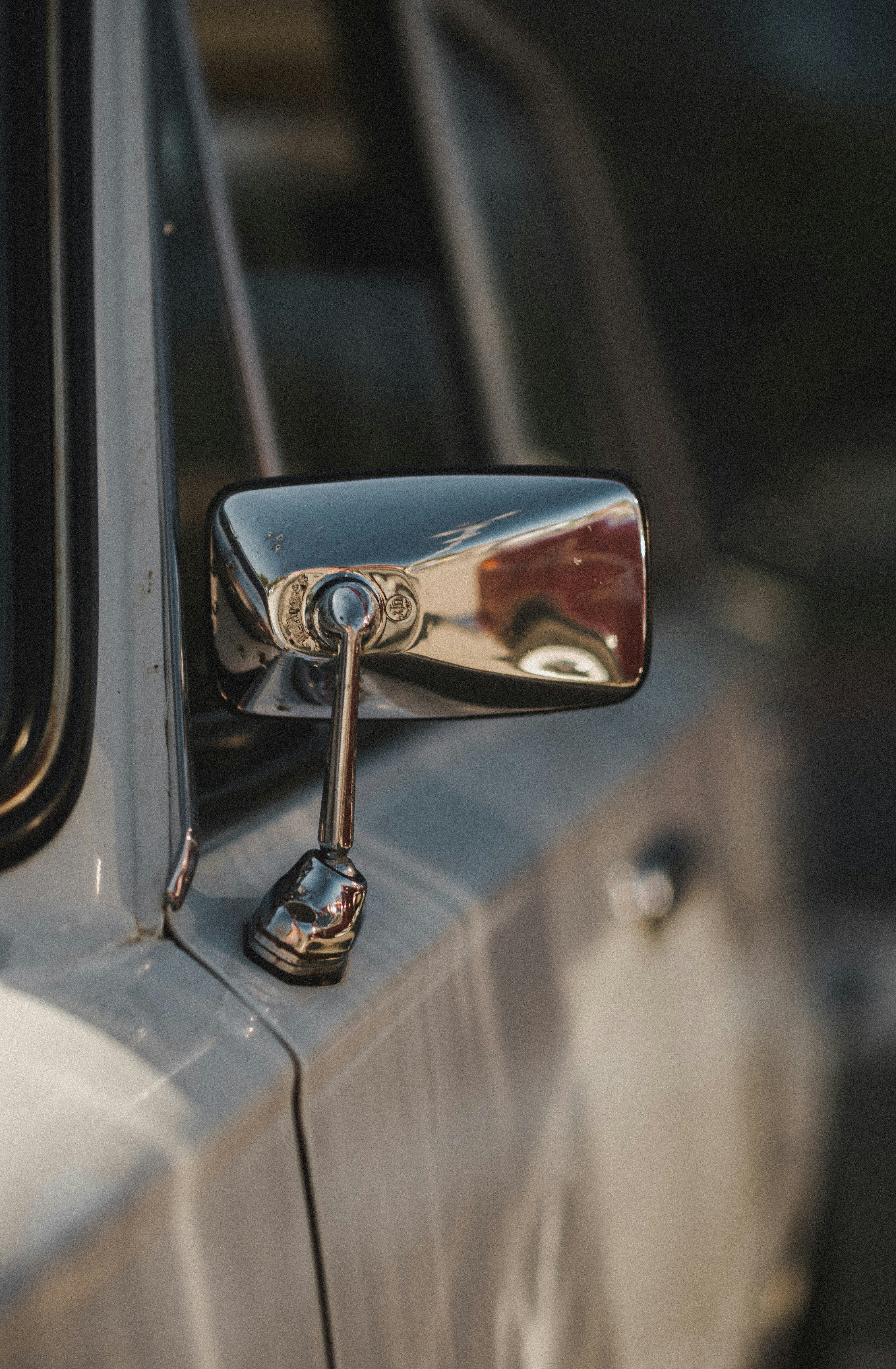 Chrome Echo: A close-up of a vintage car's side mirror and door handle