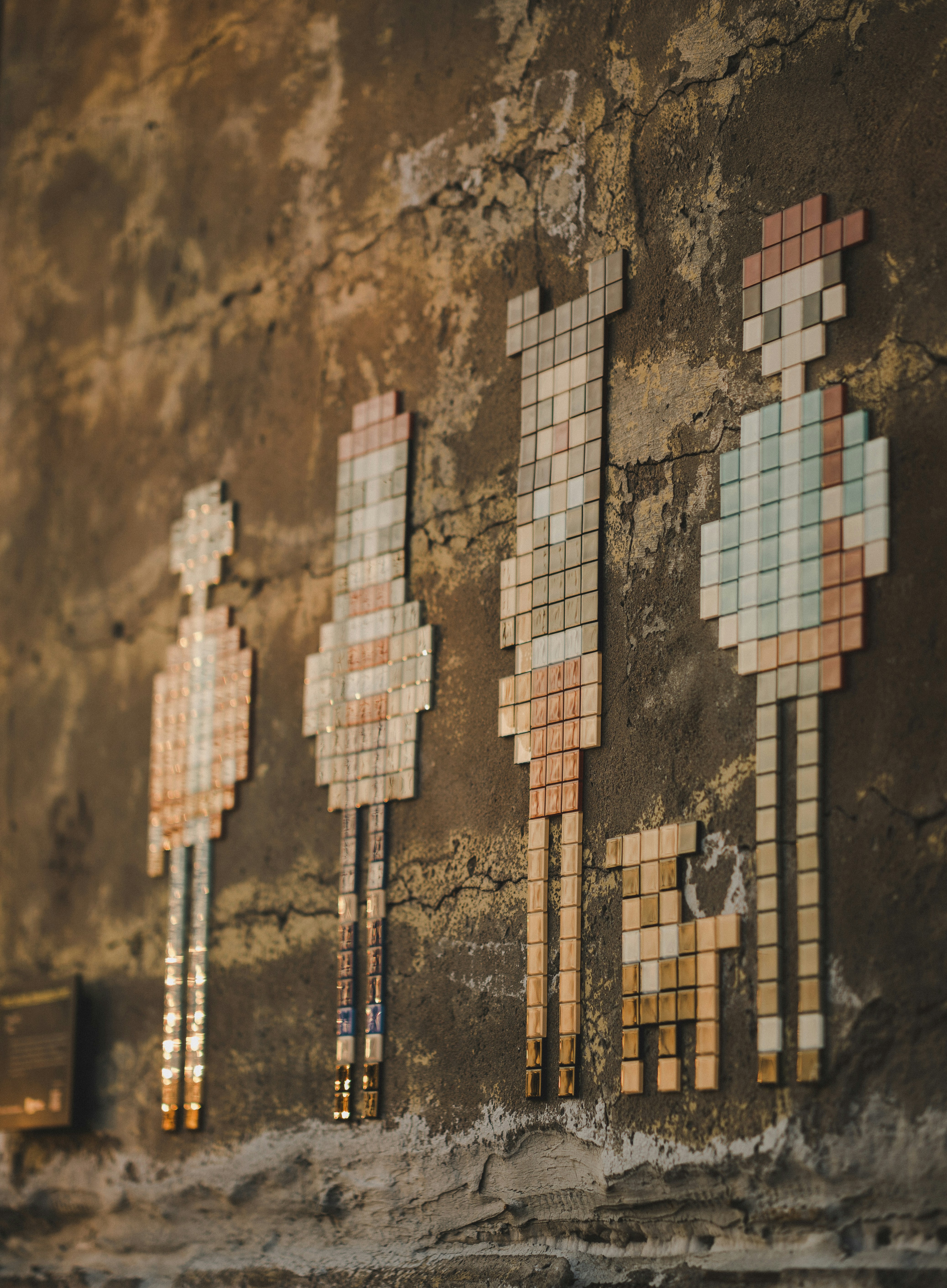 Five Tile Figures on a Cracked Concrete Wall
