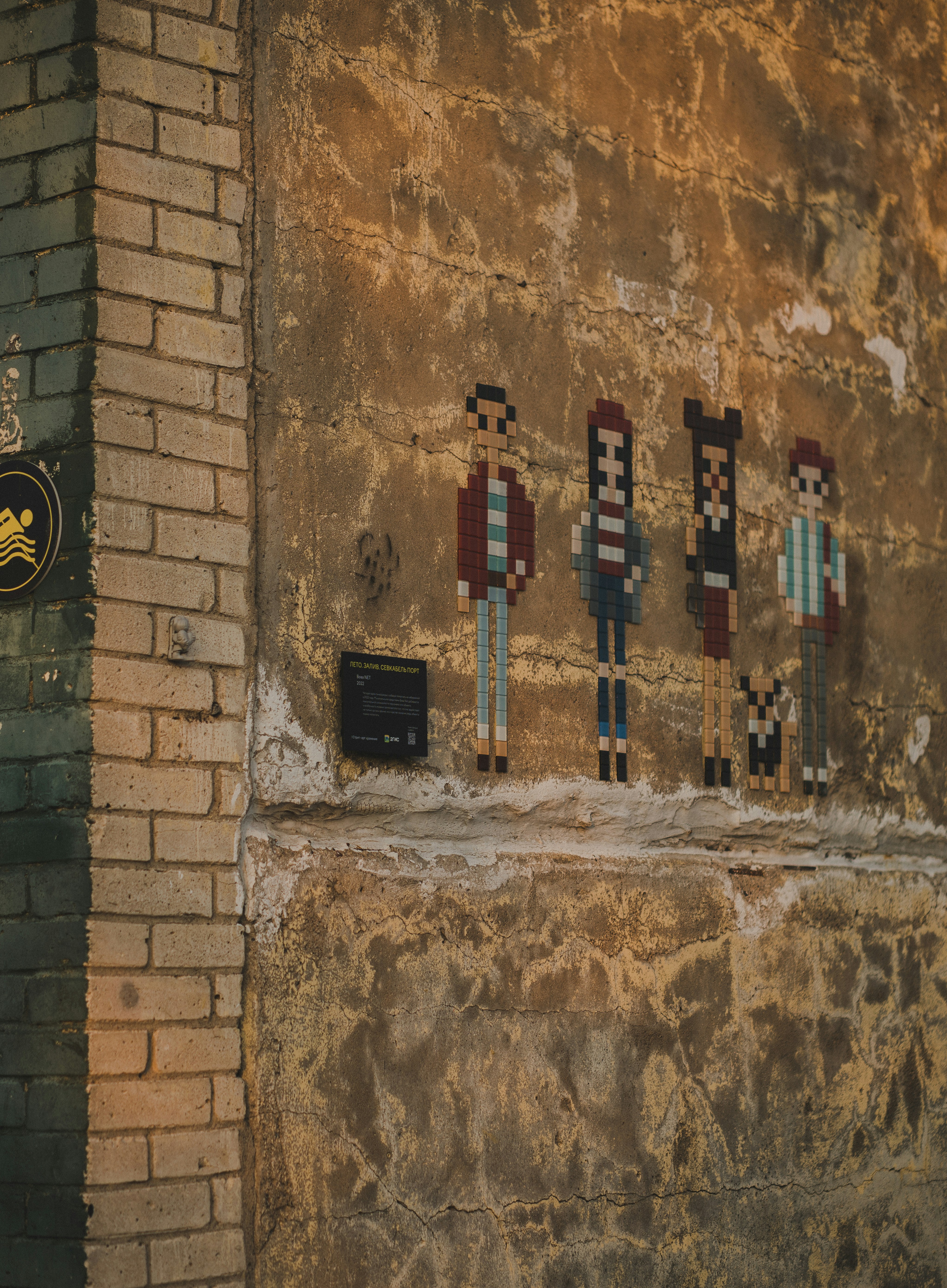 Pixel Folk on a Weathered Wall: A Quiet Street Mosaic