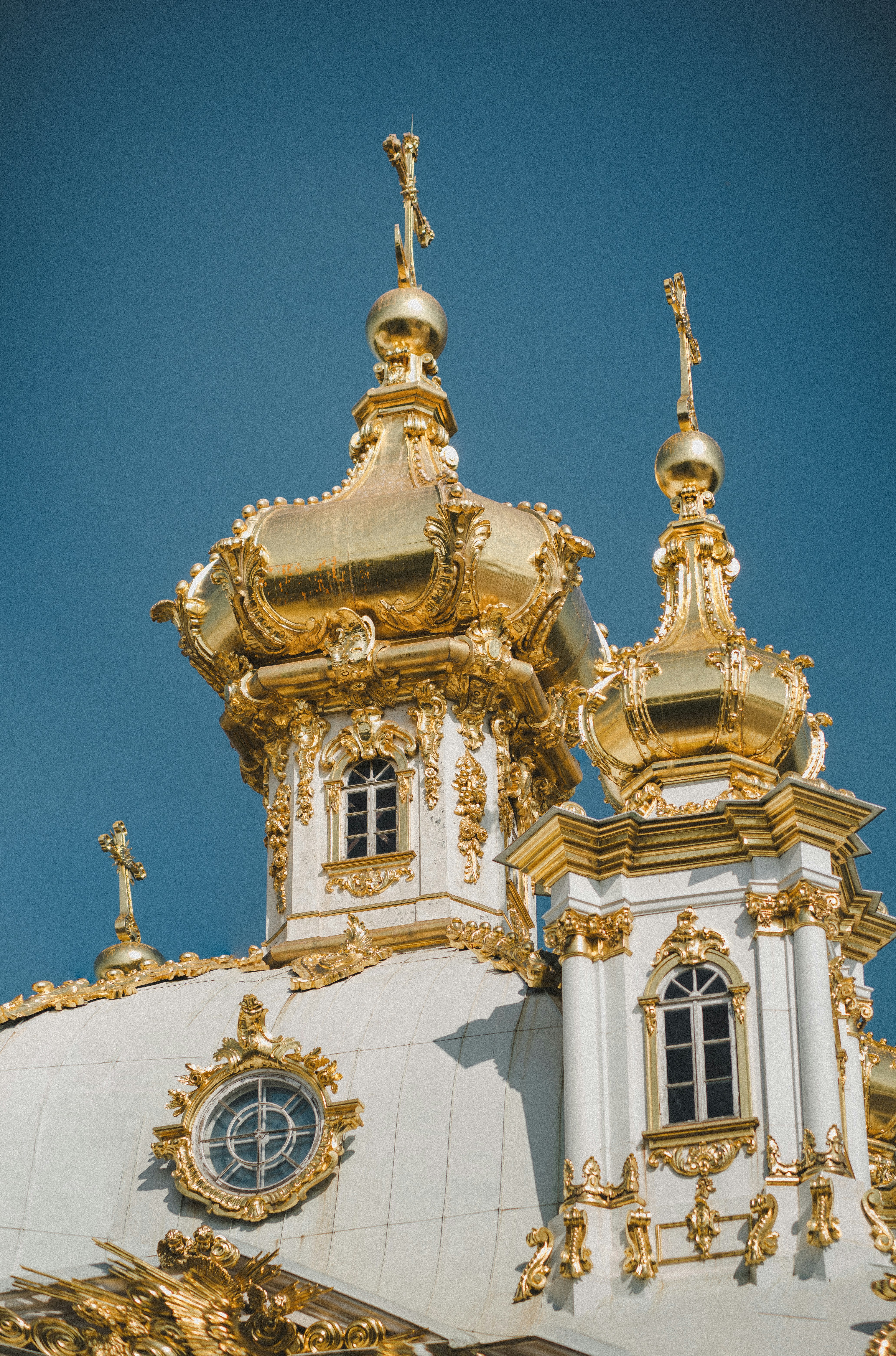 A large white and gold building with a clock on it's side photo – Free ...
