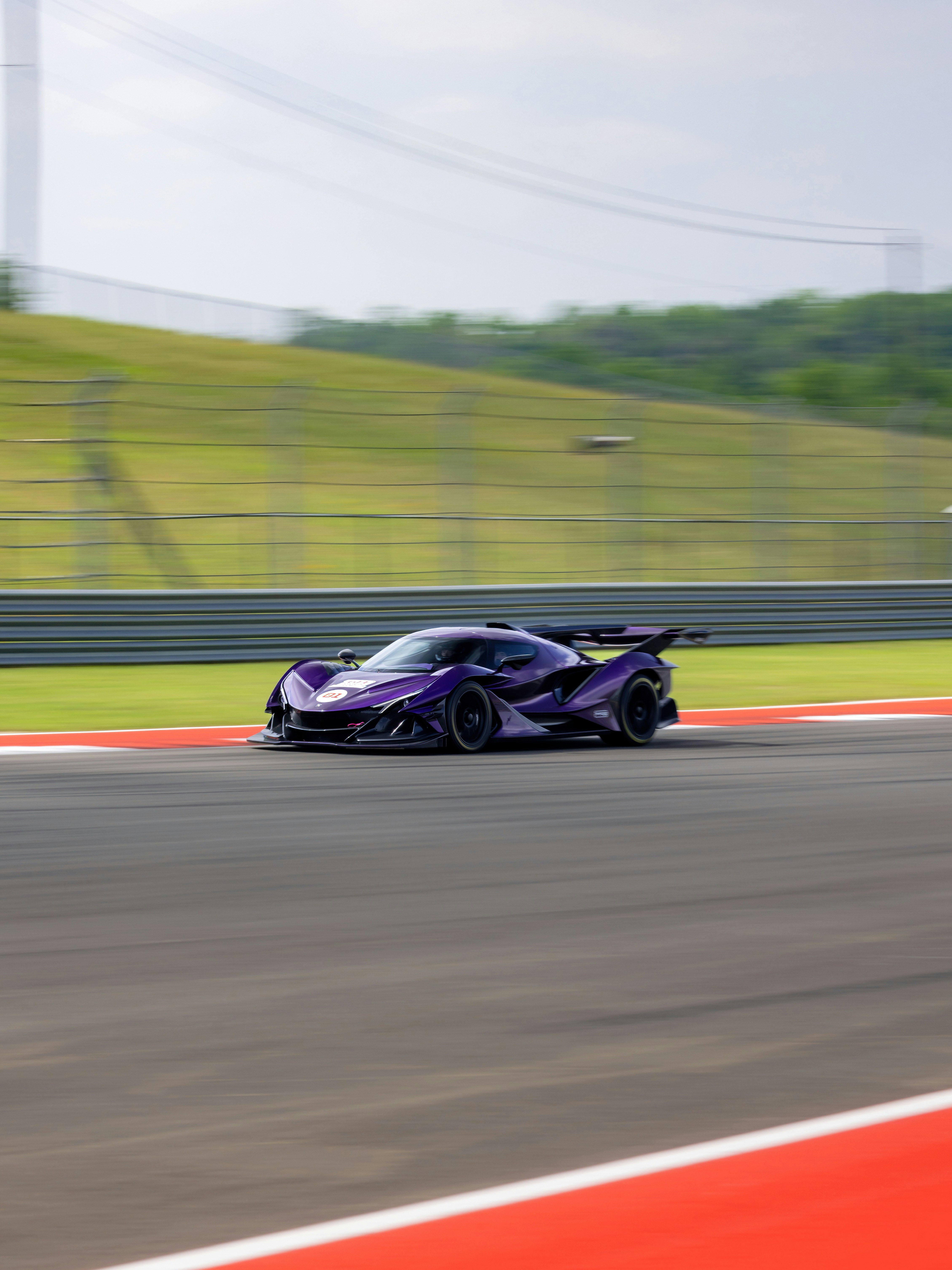 A purple race car driving down a race track photo – Free Zonda Image on ...