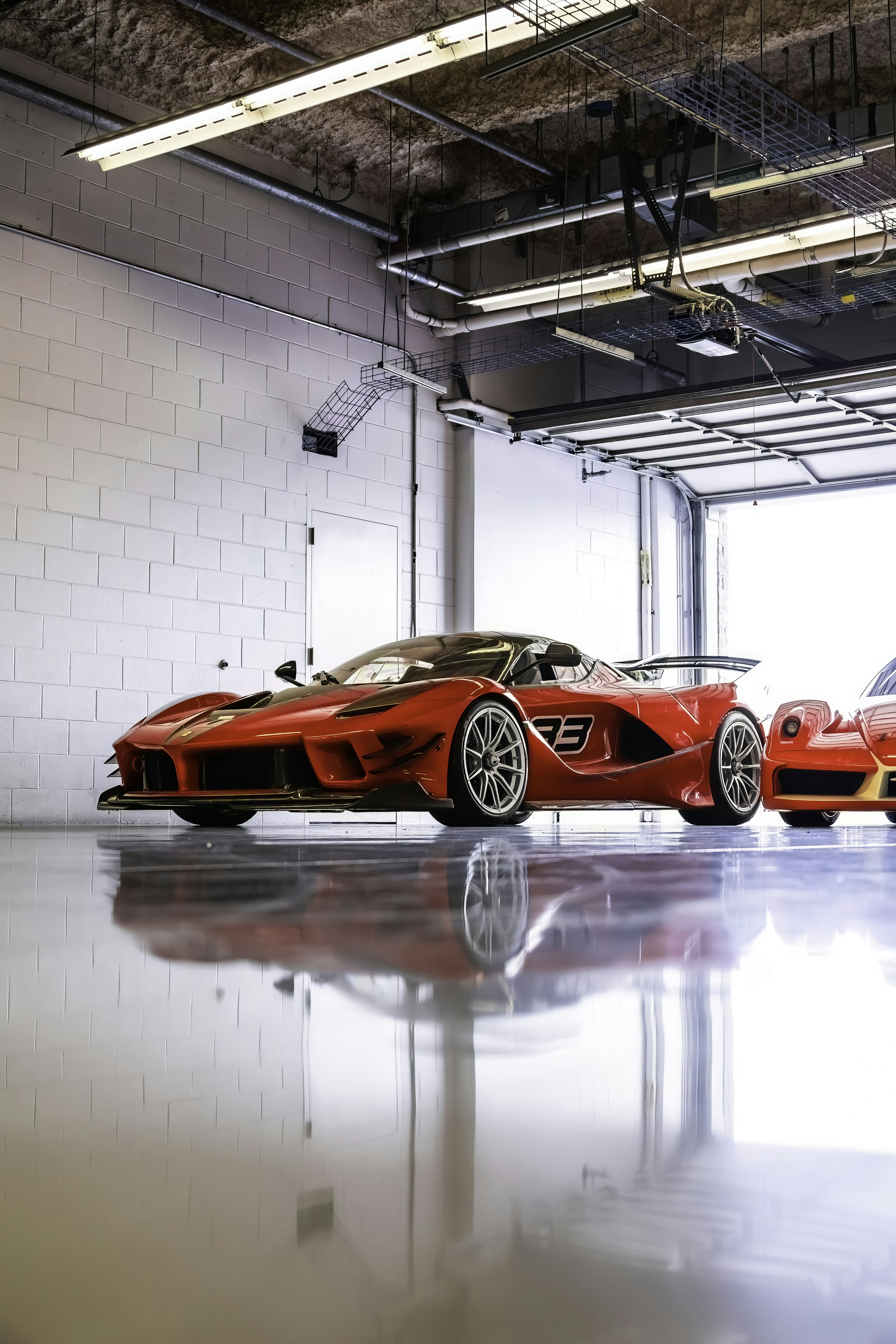 Two red sports cars parked in a garage photo – Free Ferrari Image on ...