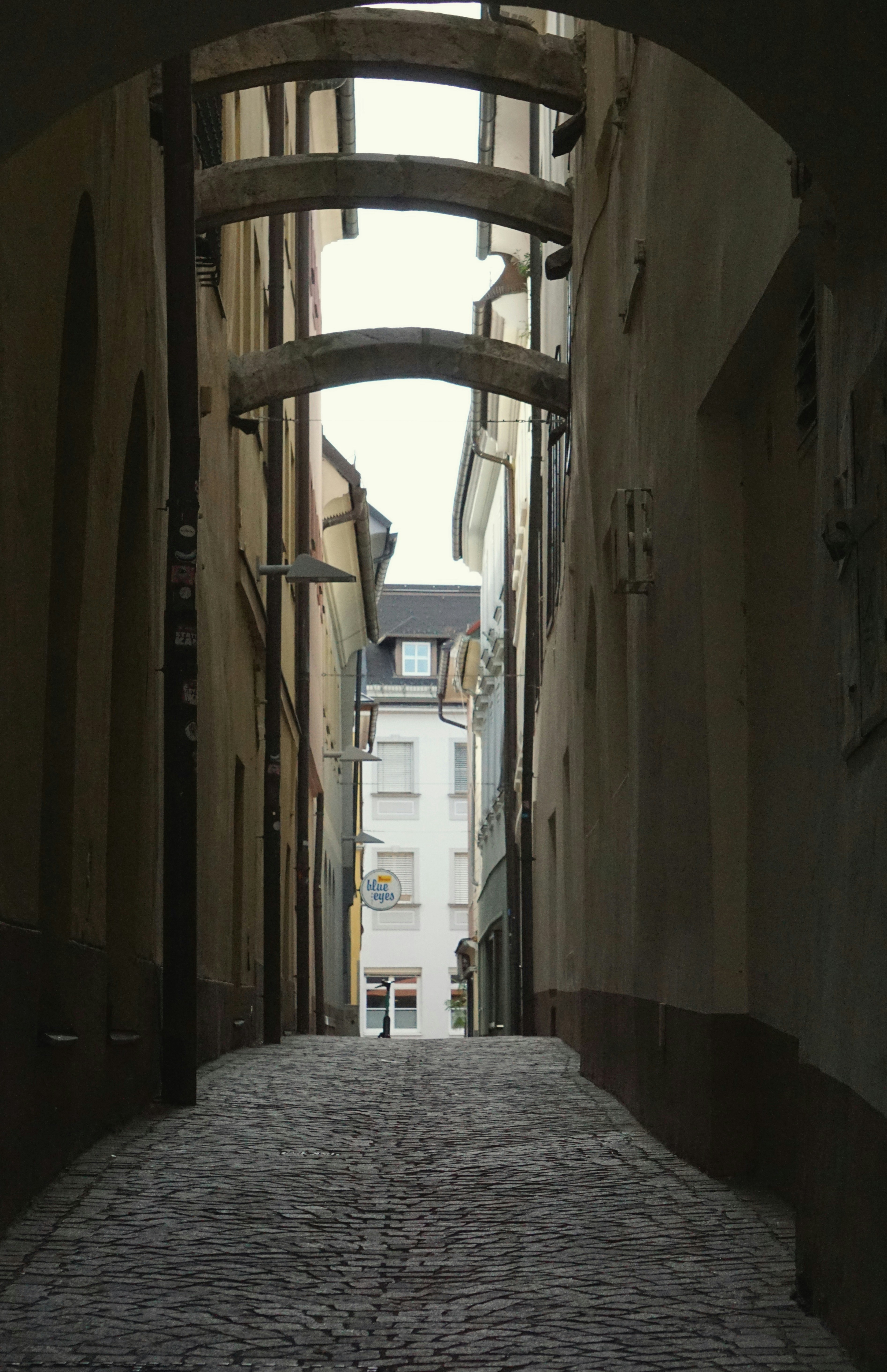 A narrow alleyway with a stone walkway between two buildings photo ...