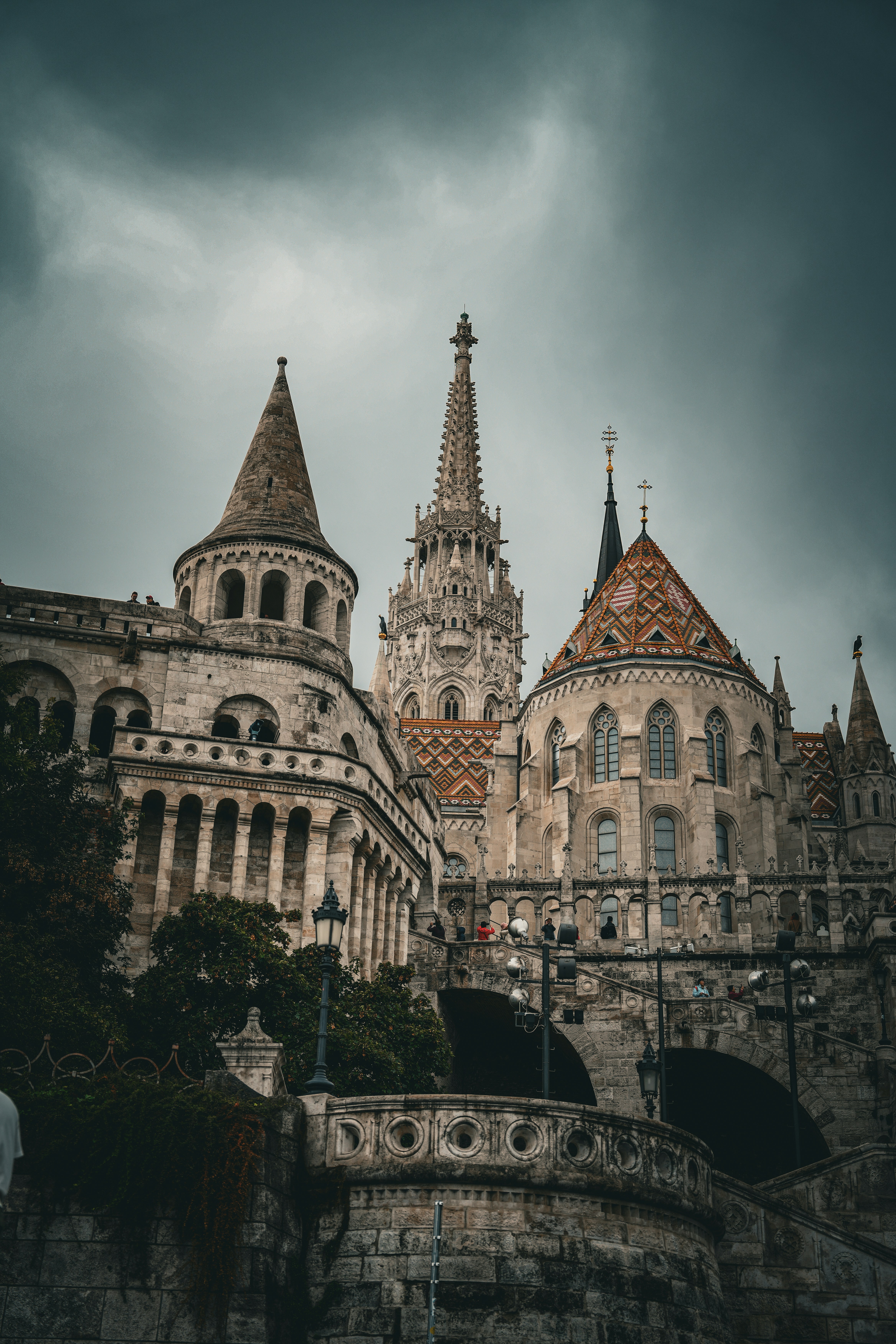 Stone Choir of Towers: a medieval riverside fortress under brooding skies