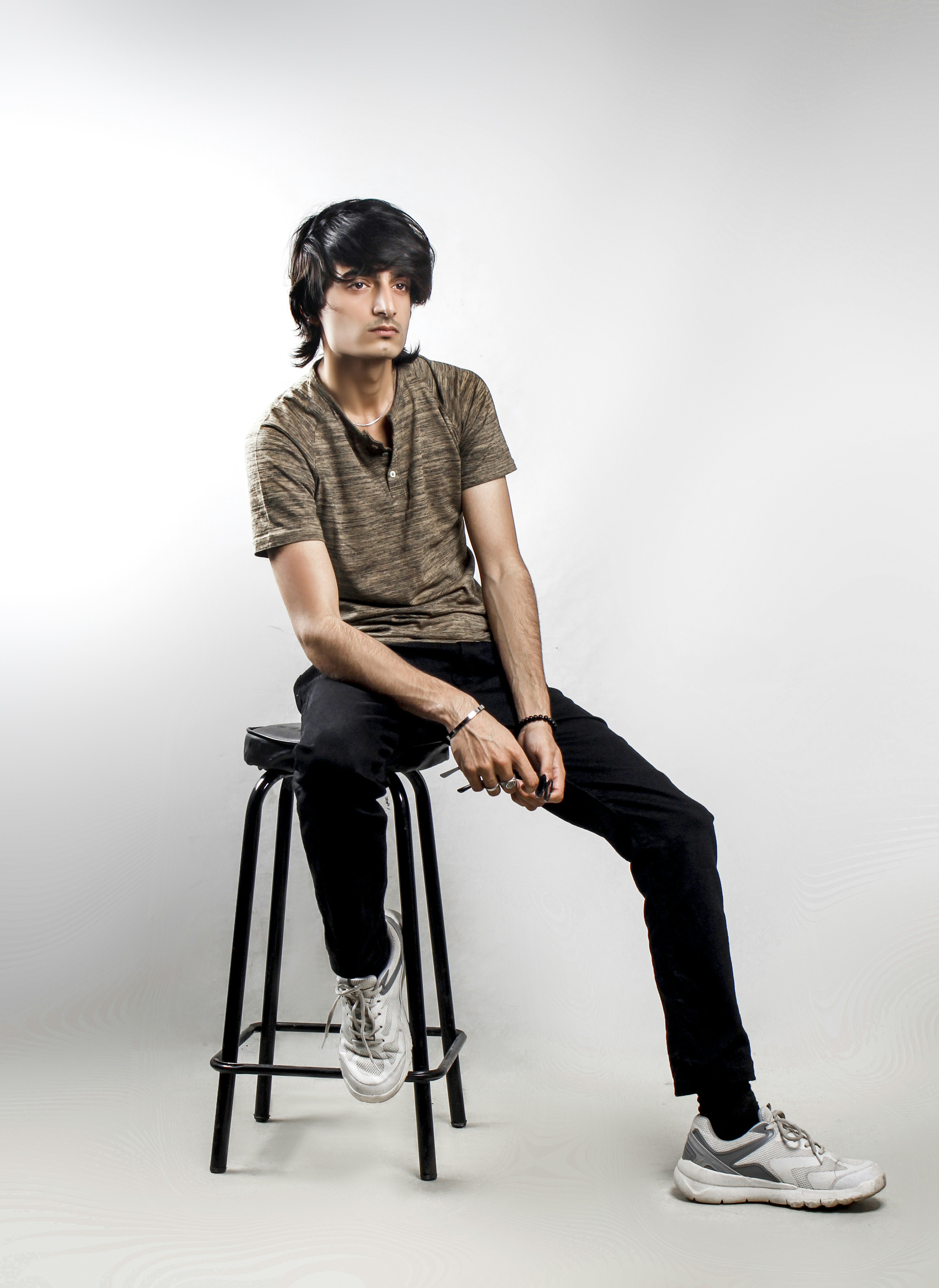 A man sitting on top of a black stool photo – Free Naeem ad studios Image on Unsplash