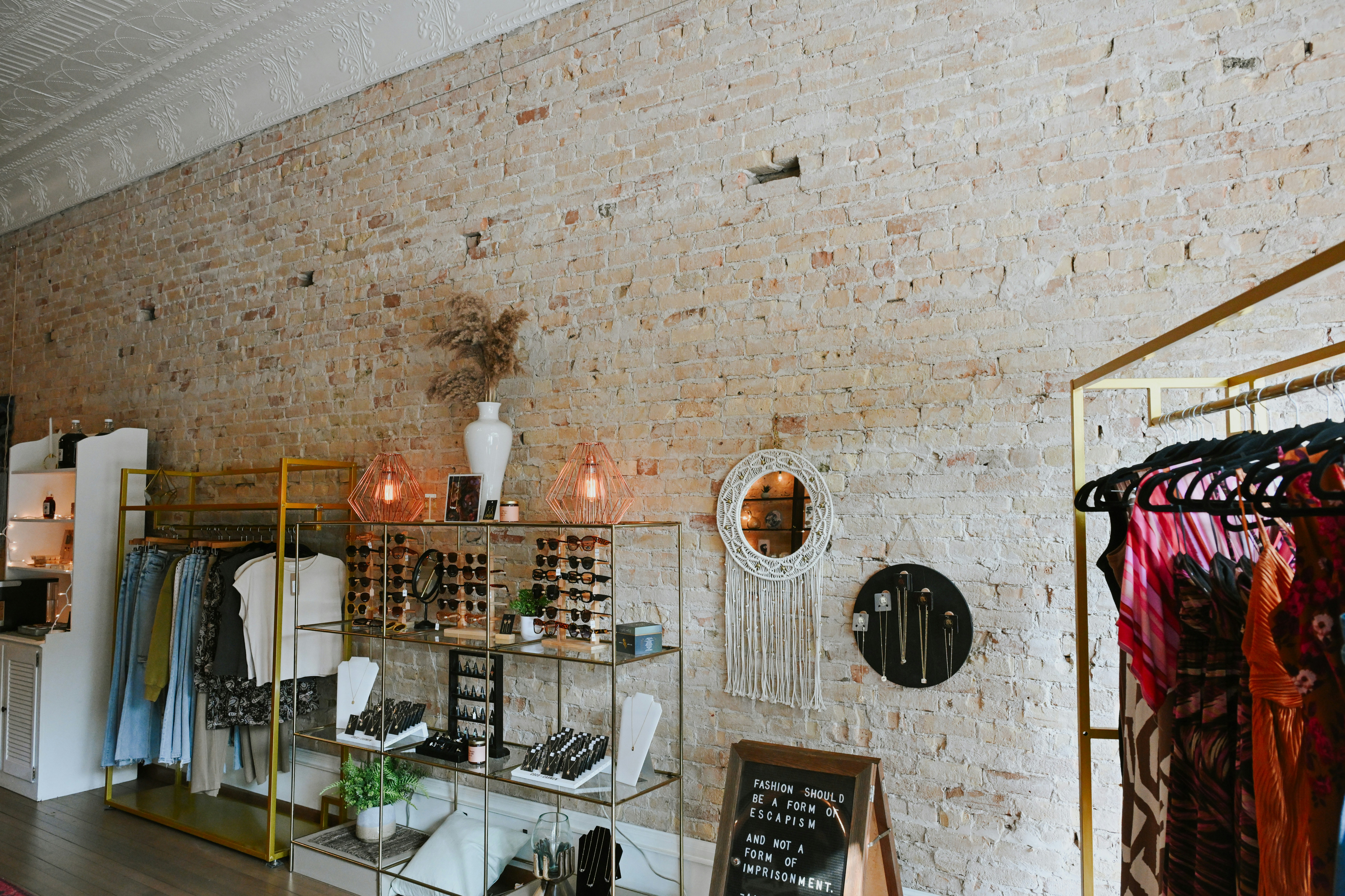 Una tienda de ropa con una pared de ladrillos y mucha ropa foto ...
