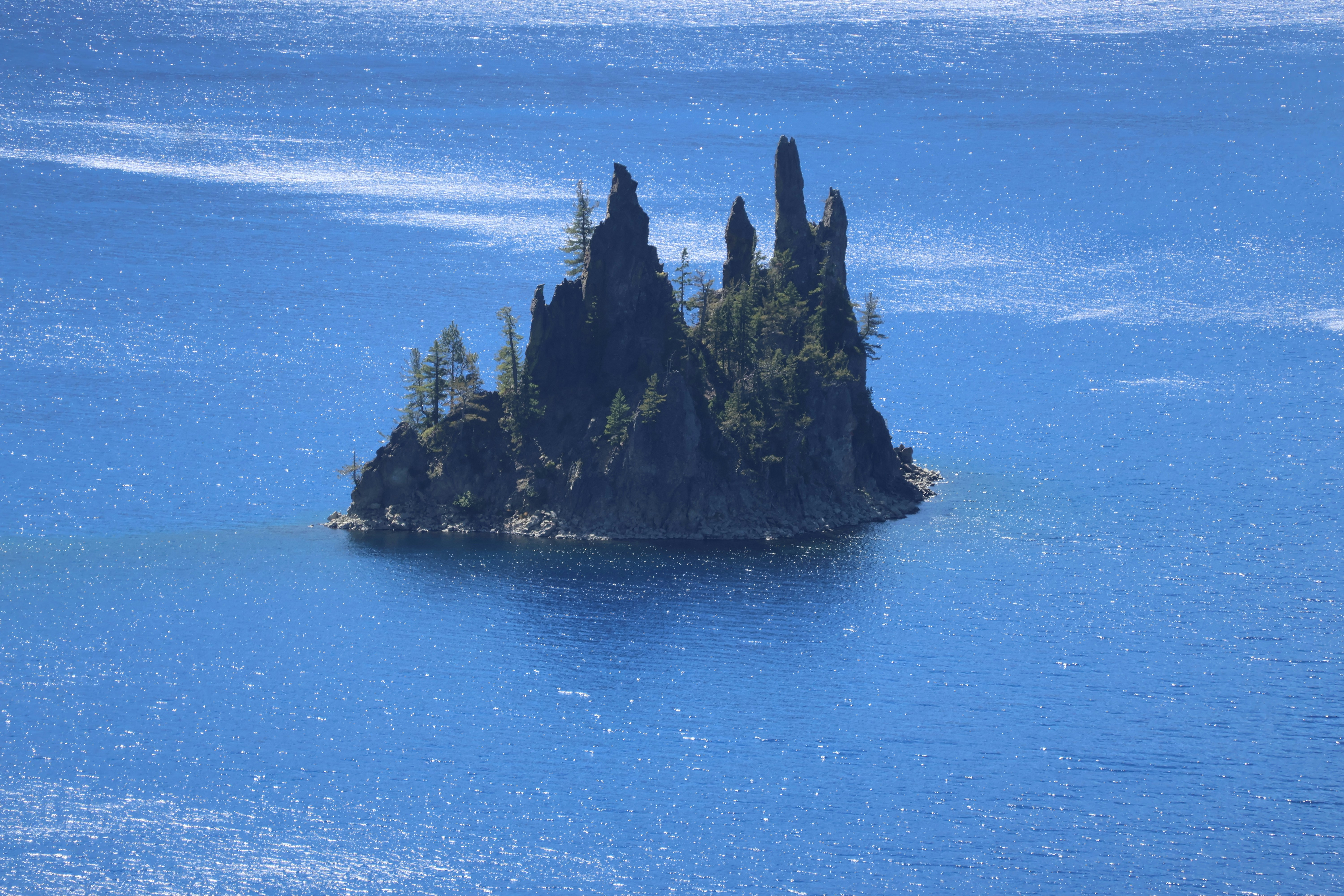 Spires of the Cerulean Sea: A Lone Pine-Crowned Islet Rising from Blue Tide