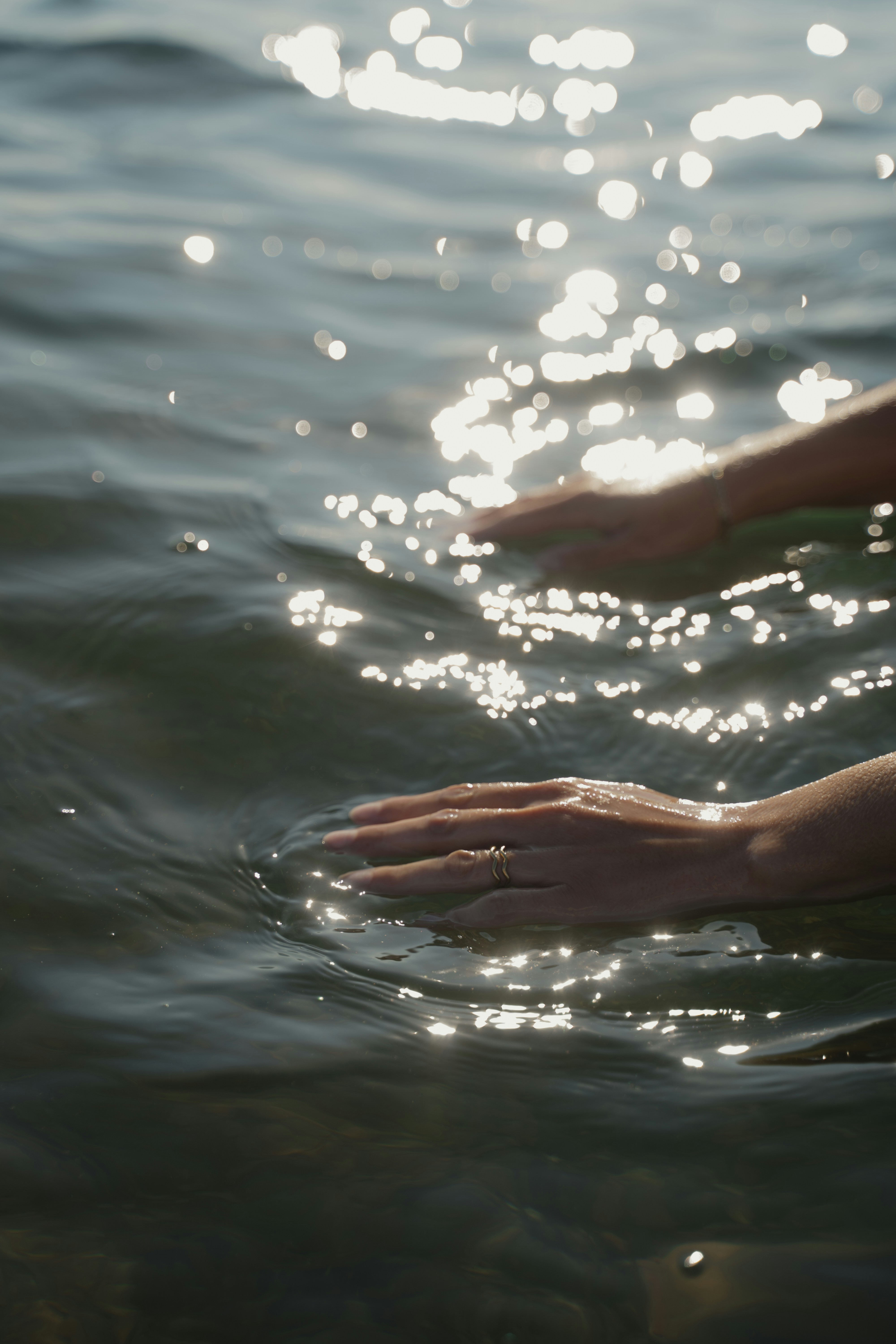 A person floating in the water with their hands in the water photo ...