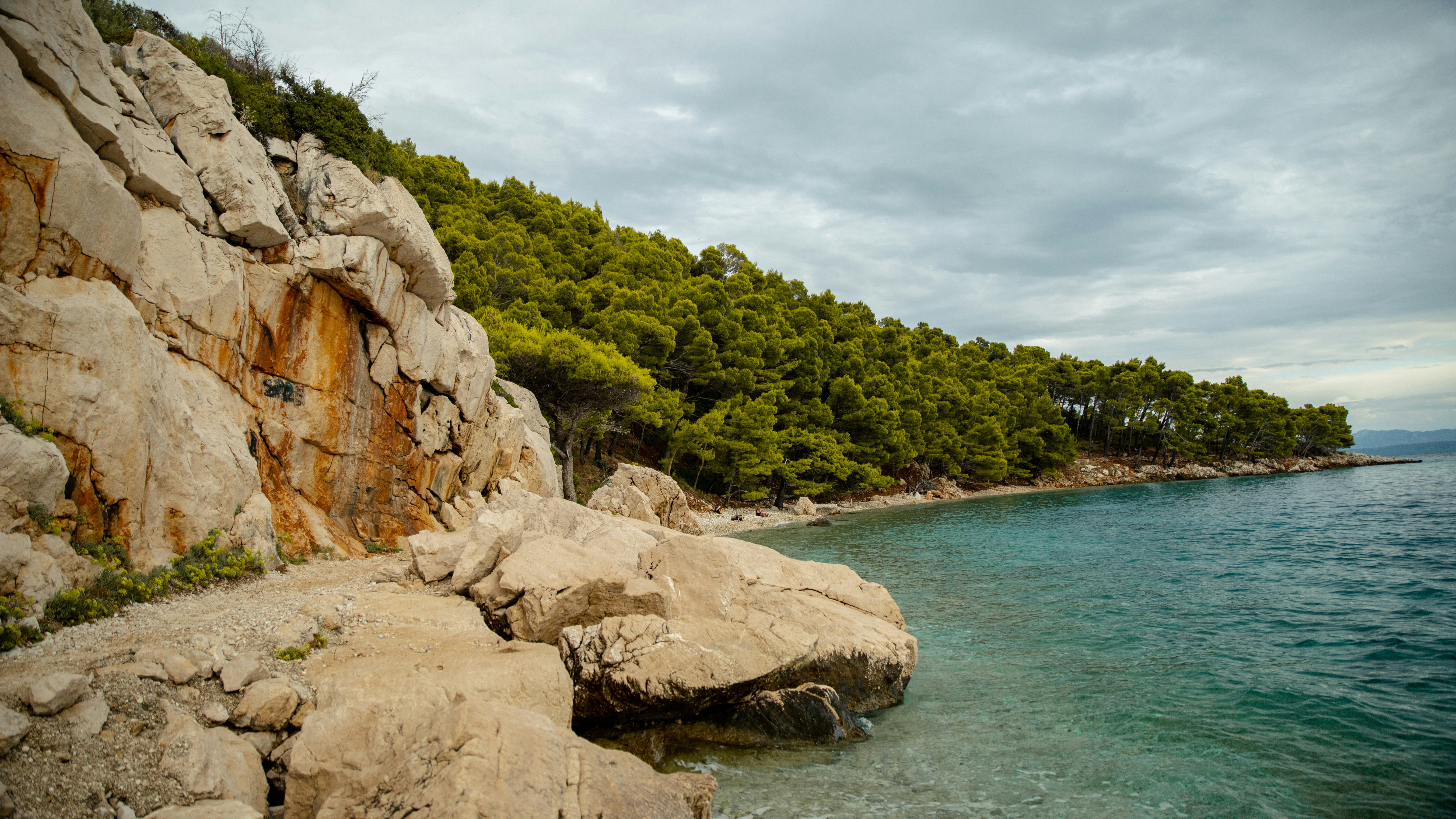 A body of water surrounded by rocks and trees photo – Free Makarska ...