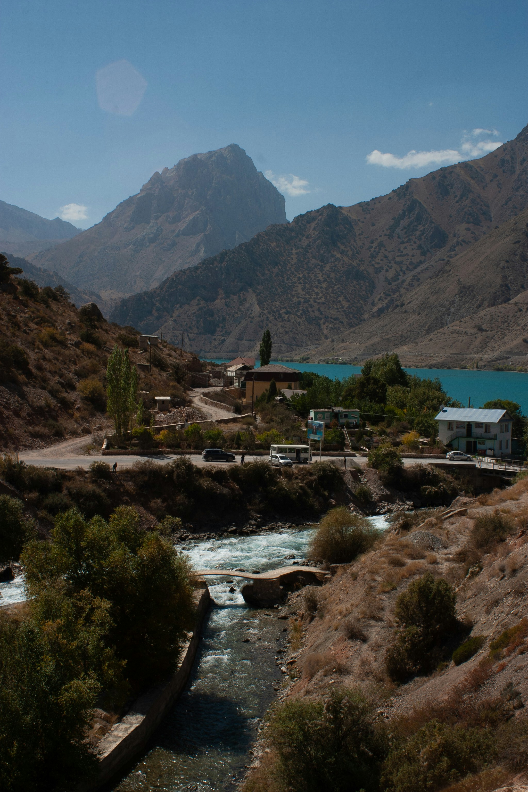 Mountain village by a turquoise lake under a towering peak
